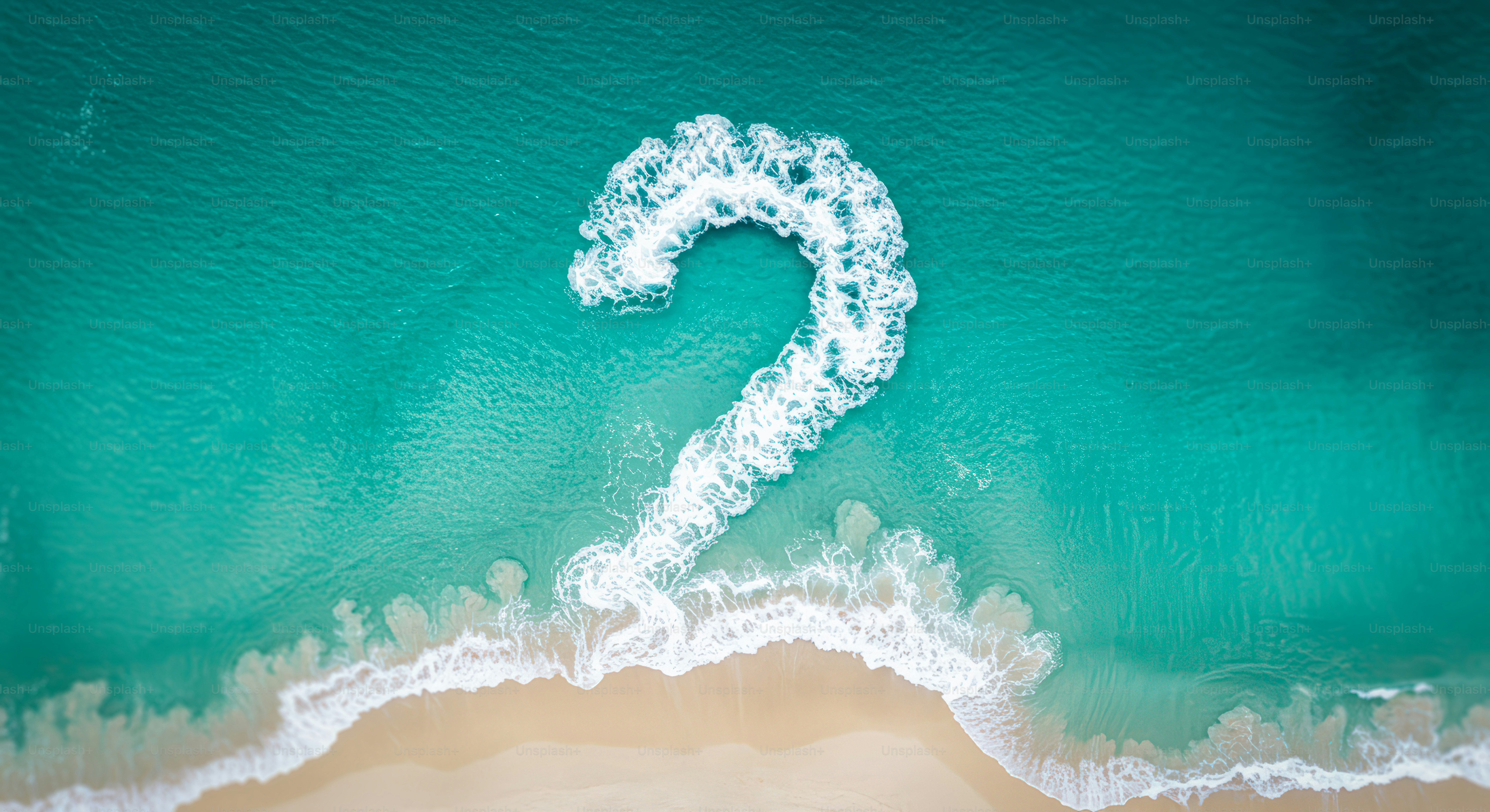 Ocean foam forms the number two on a beach. photo – Beach Image on Unsplash