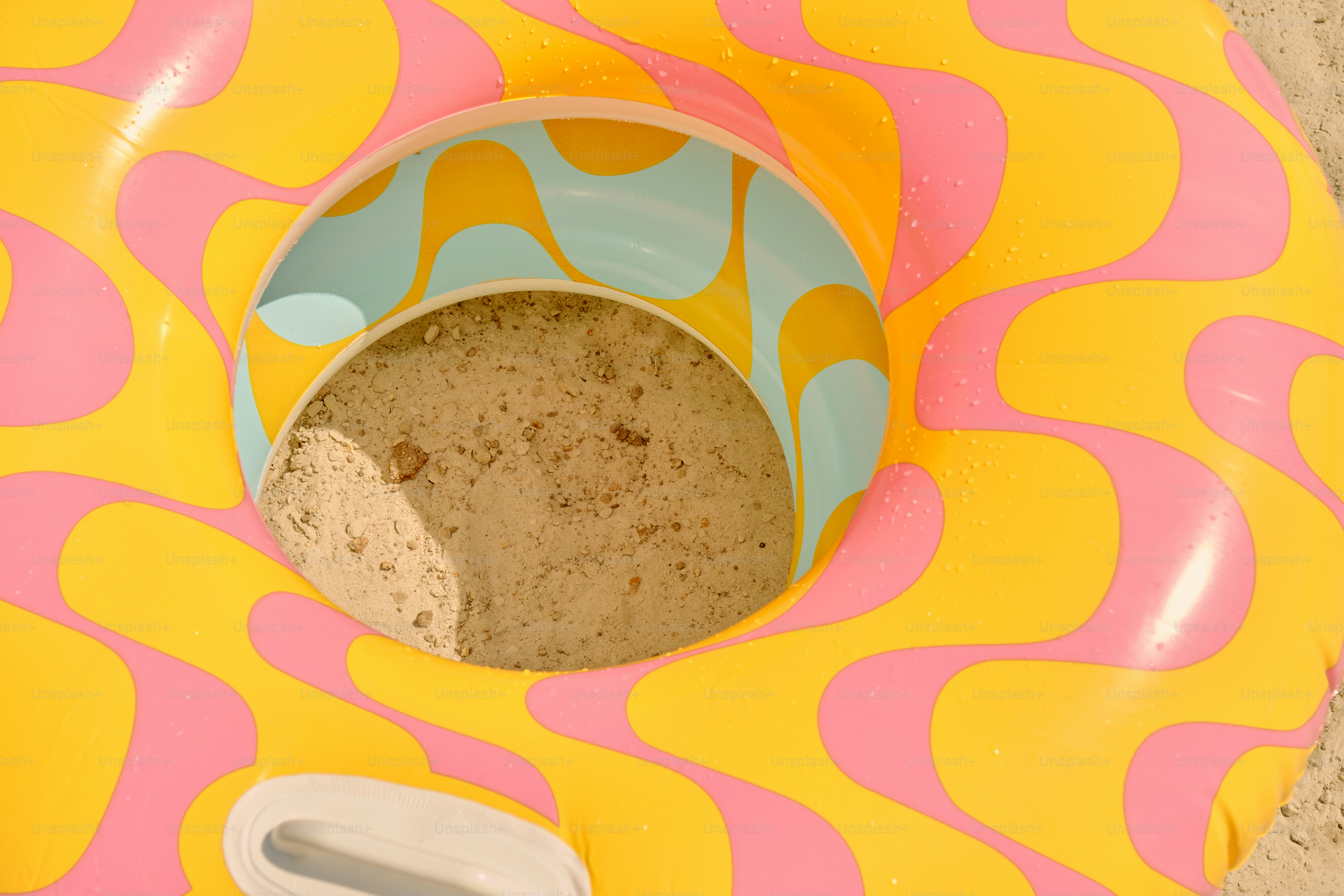 A colorful inner tube on the beach sand. photo – Beach Image on Unsplash