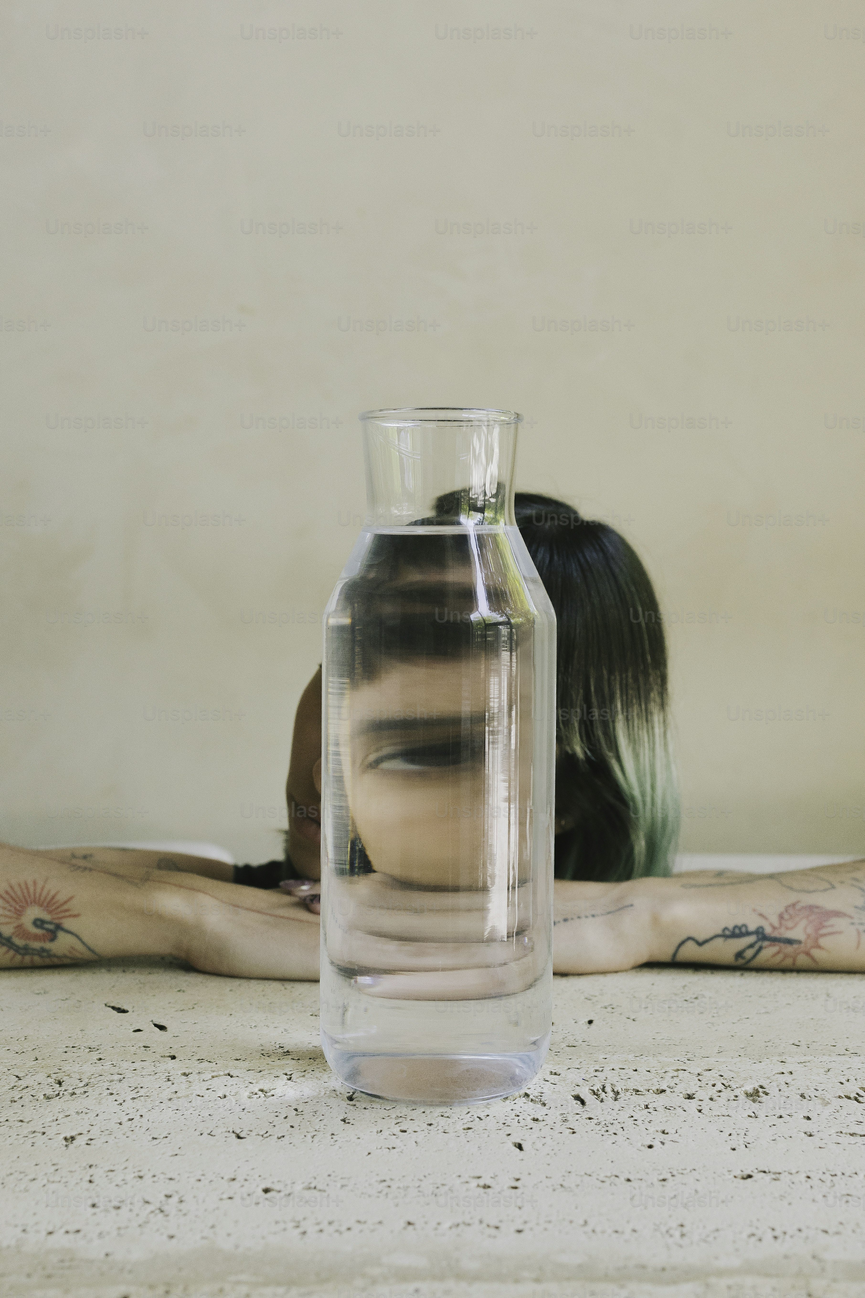 Person's face appears distorted through a water carafe. photo ...