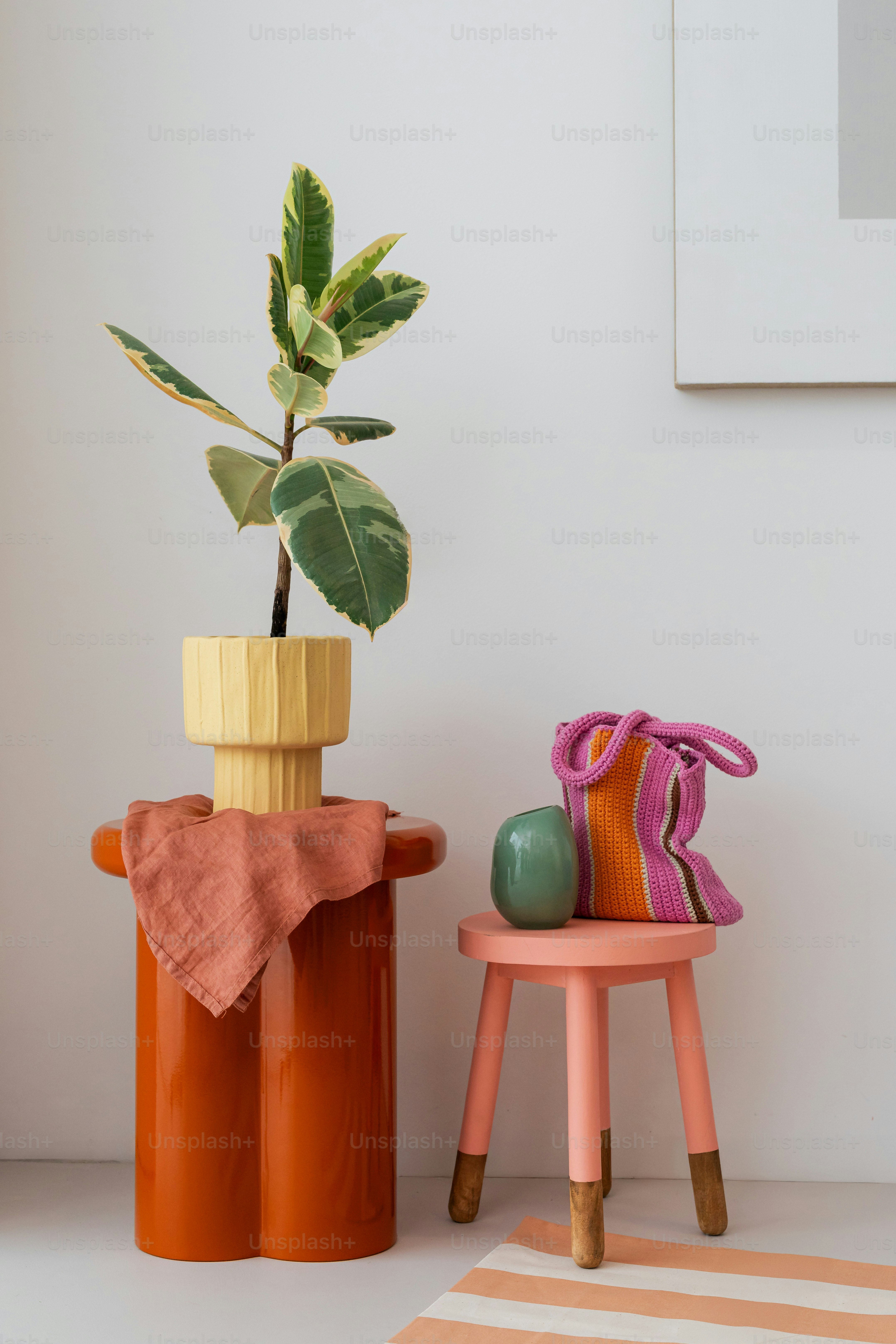 A plant, stool, and accessories decorate a room. photo – Interior ...