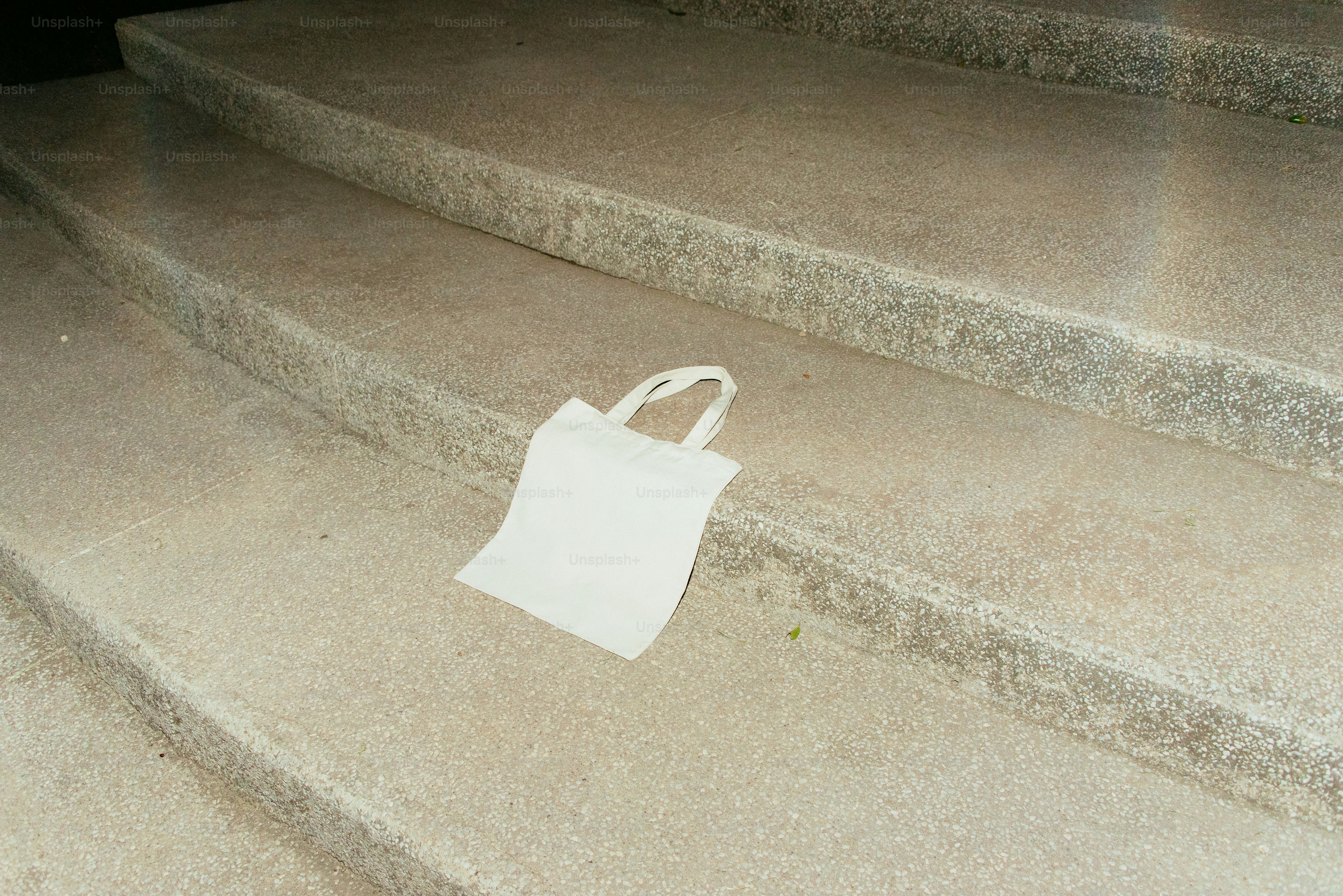A white tote bag is on the green grass. photo – Marketing Image on Unsplash