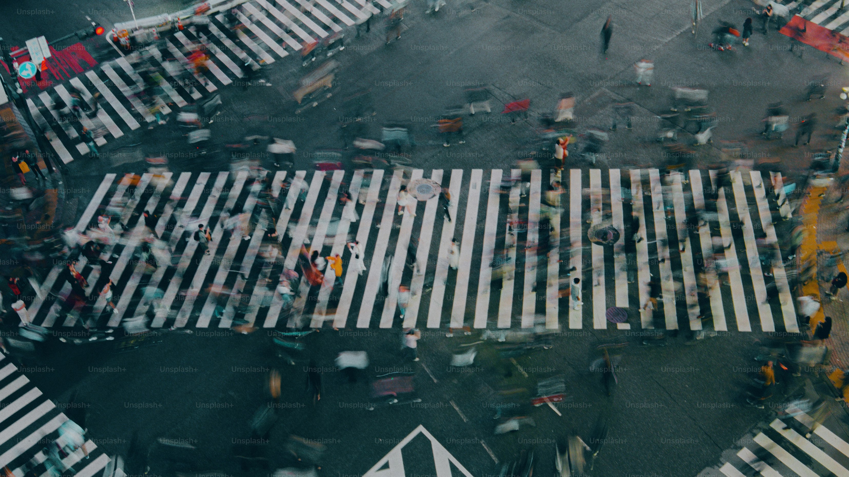 People cross a busy, striped intersection. photo – Travel Image on Unsplash