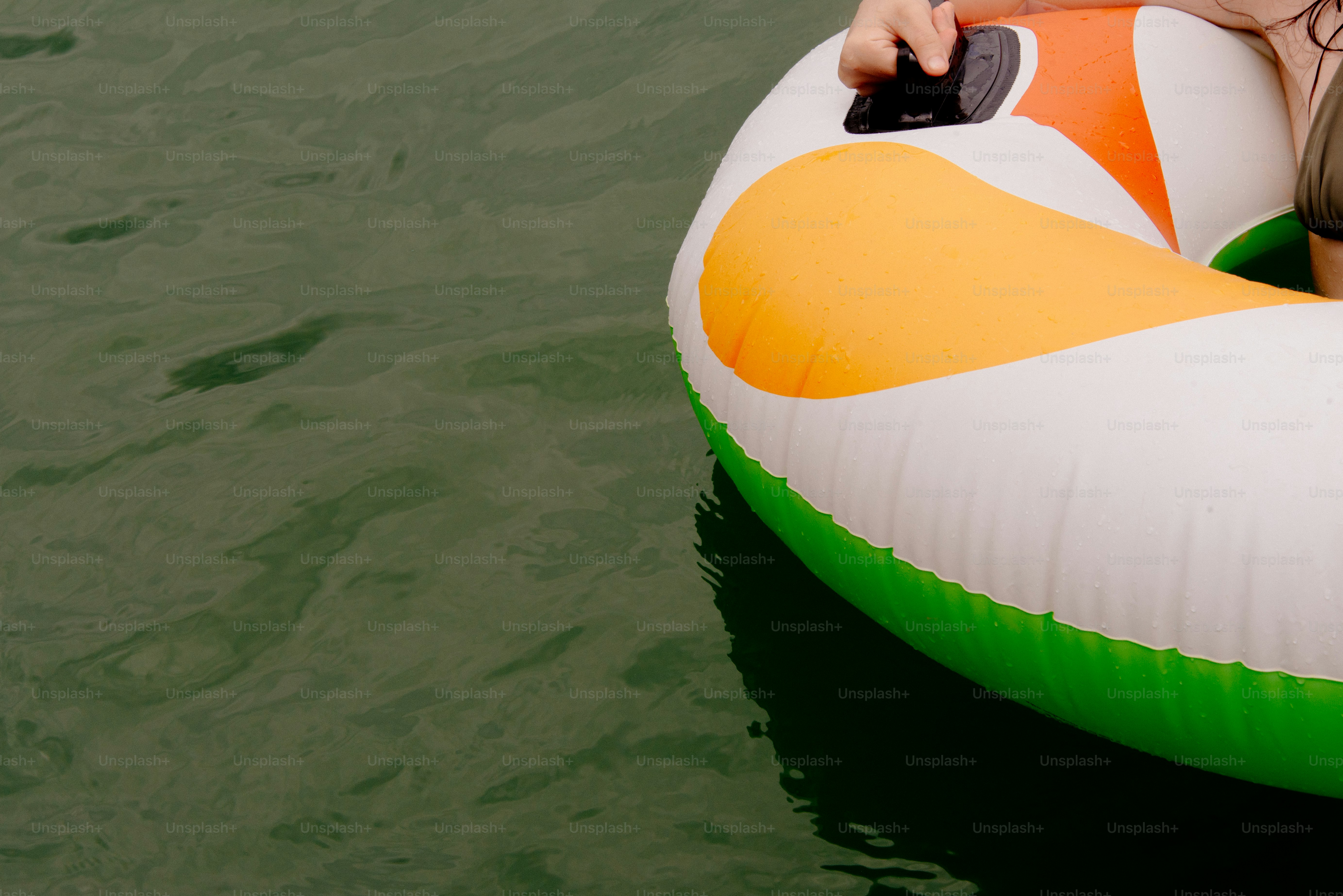 Person floats on a colorful inner tube. photo – Summer fun Image on ...