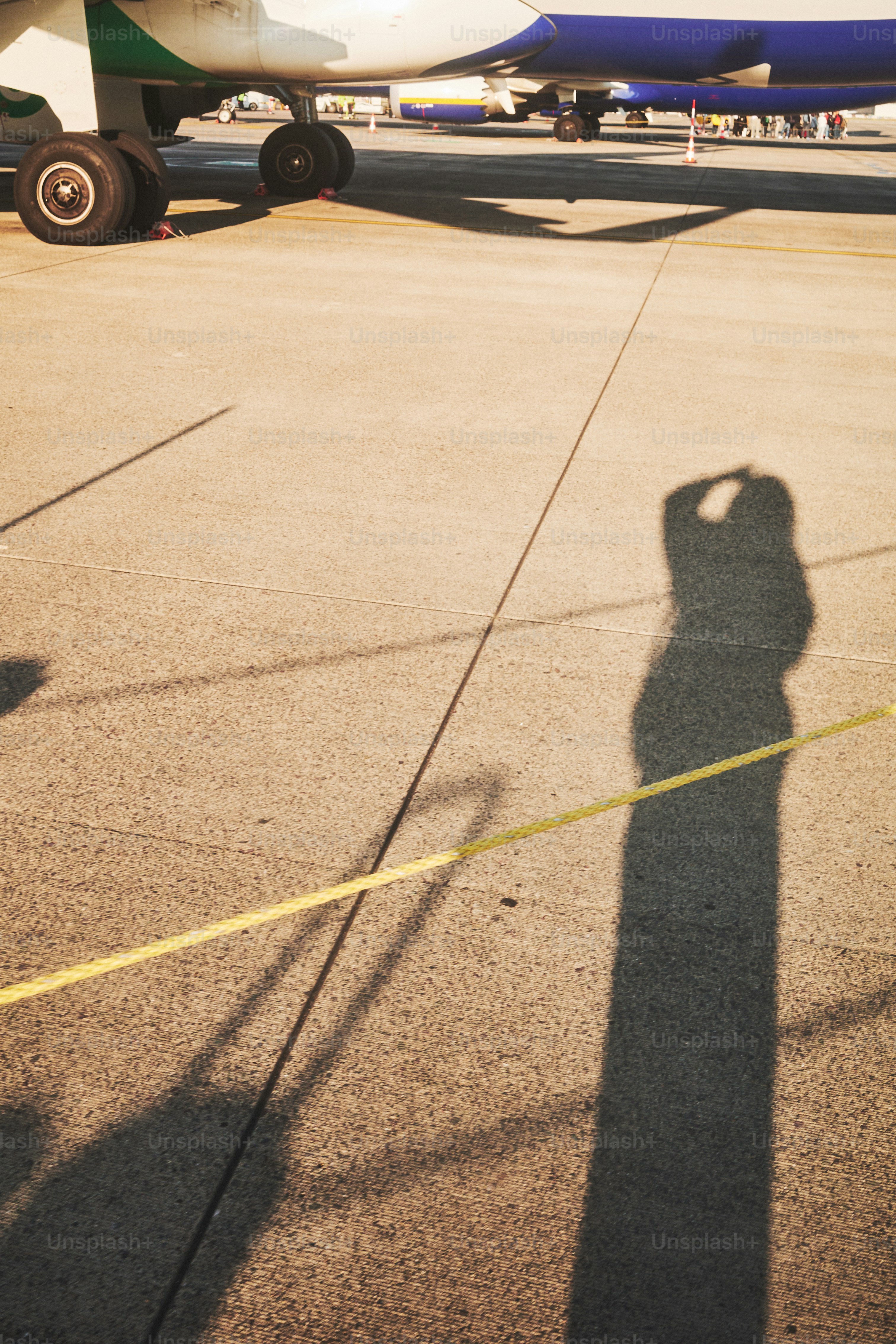 Shadow of person taking photo on airport tarmac. photo – Abstract Image ...