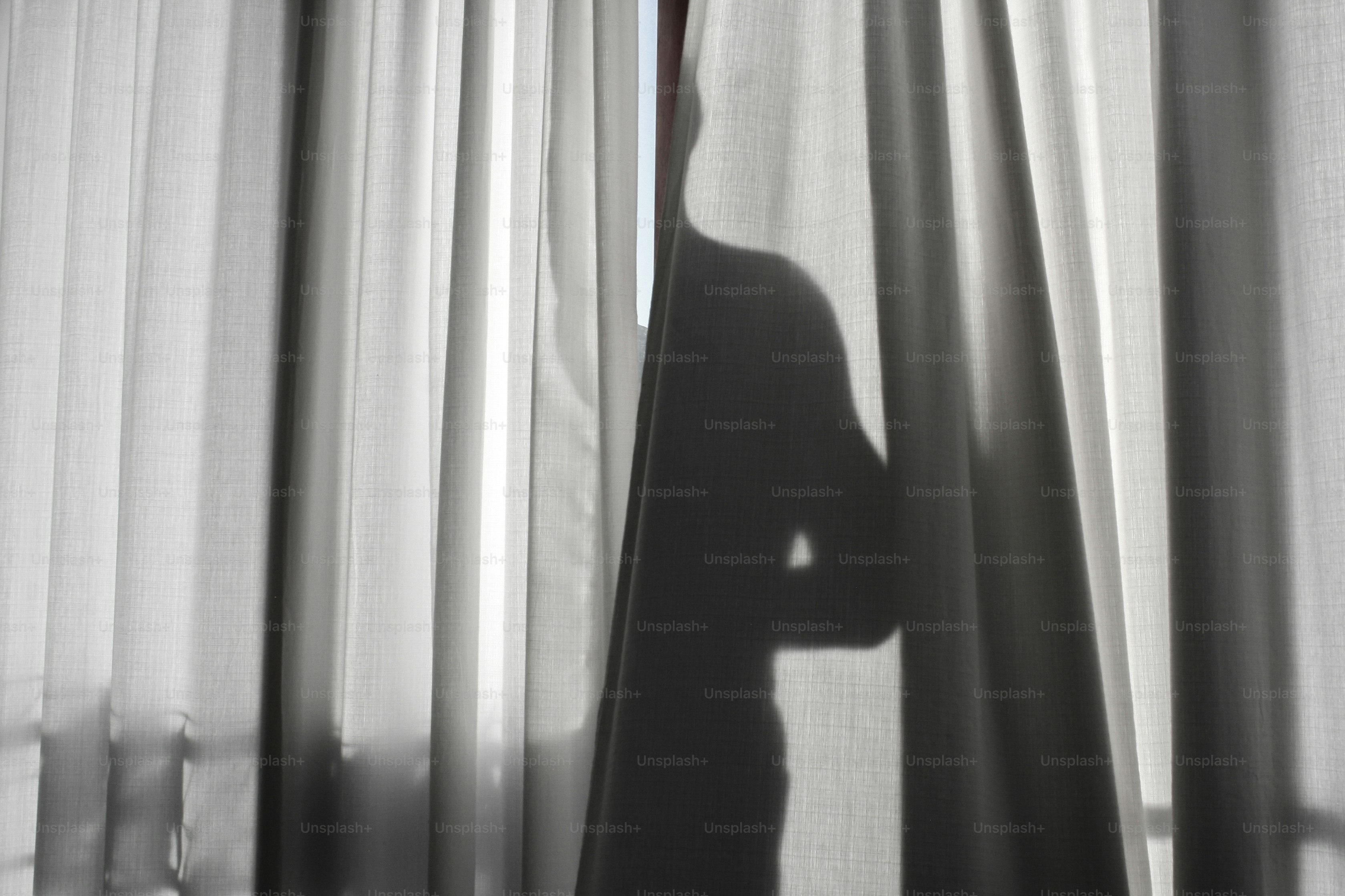 A shadow cast on curtains by sunlight. photo – Abstract Image on Unsplash