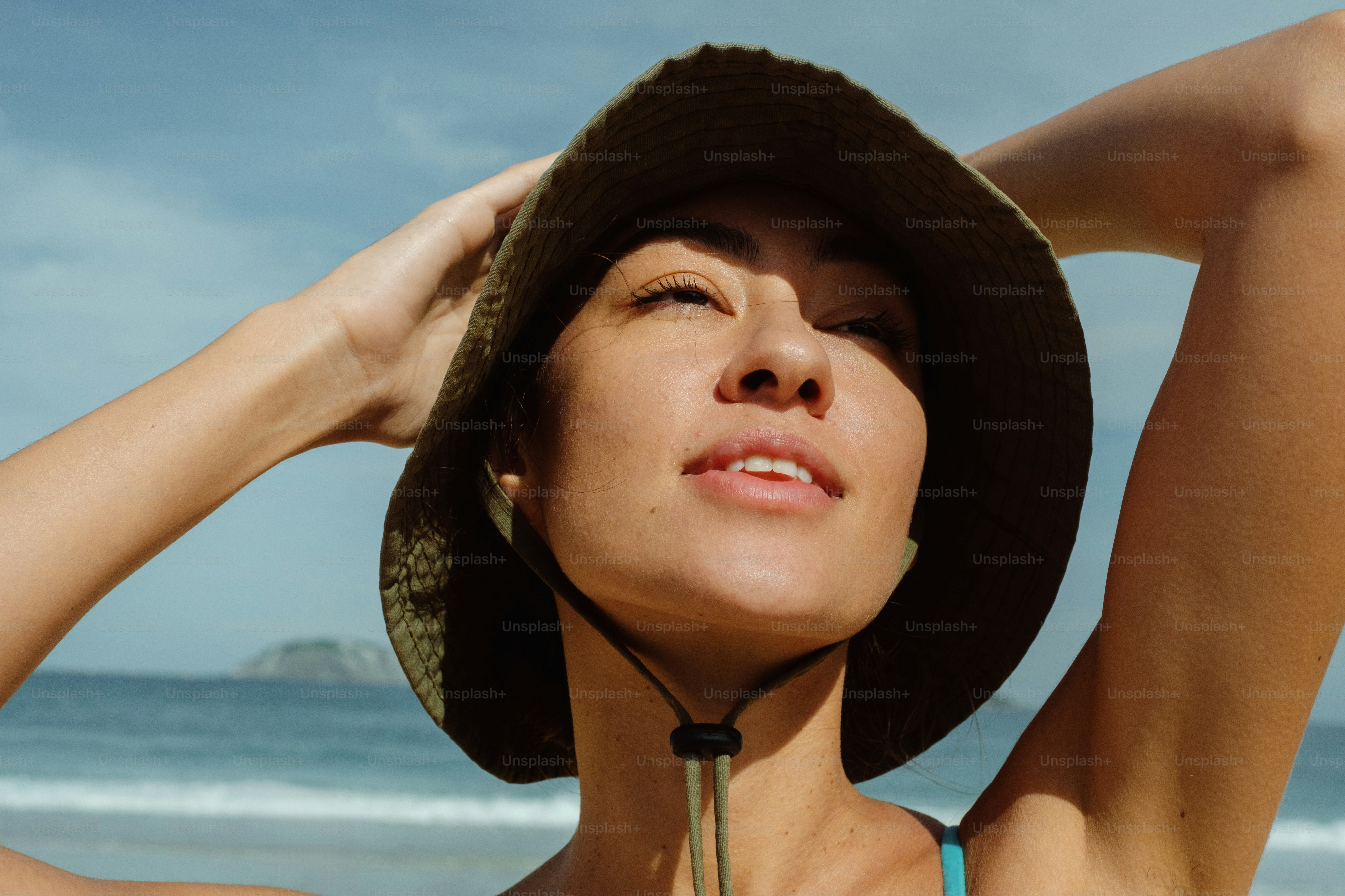 Woman in hat enjoys the sun at the beach. photo – Sun Image on Unsplash