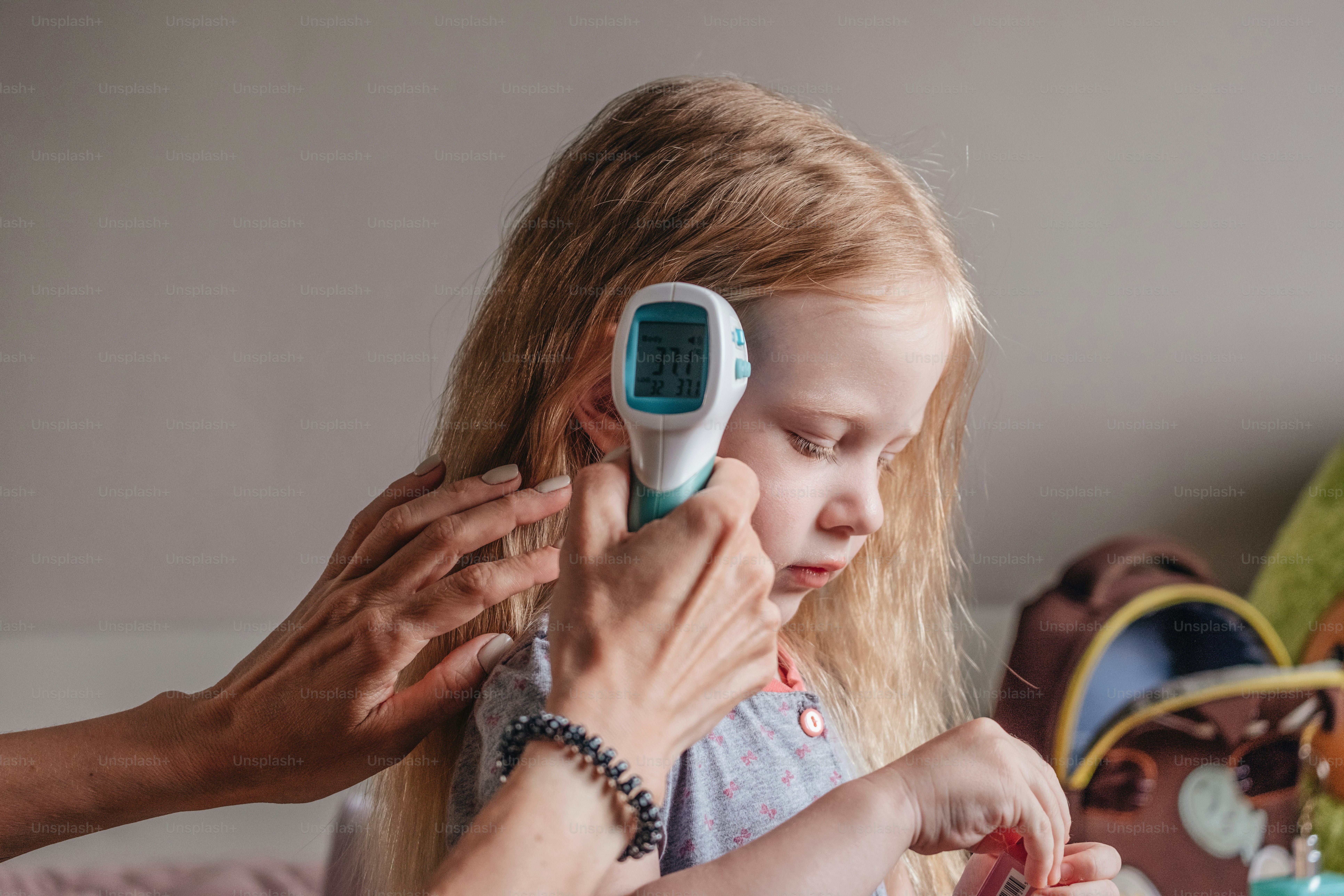 Someone is taking a child's temperature with a thermometer. photo ...