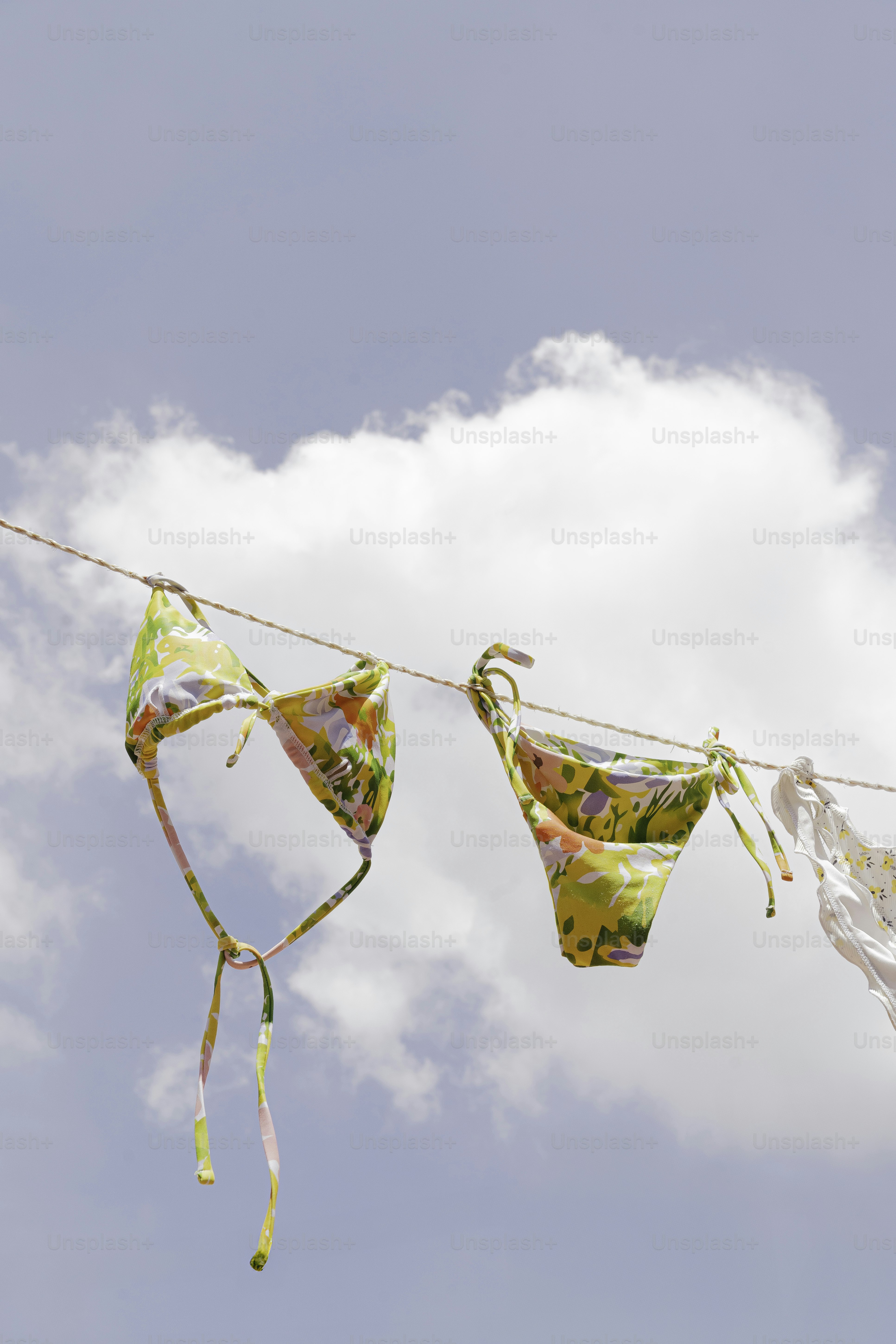 Floral bikini hangs on a clothesline under a sky. photo – Travel Image ...