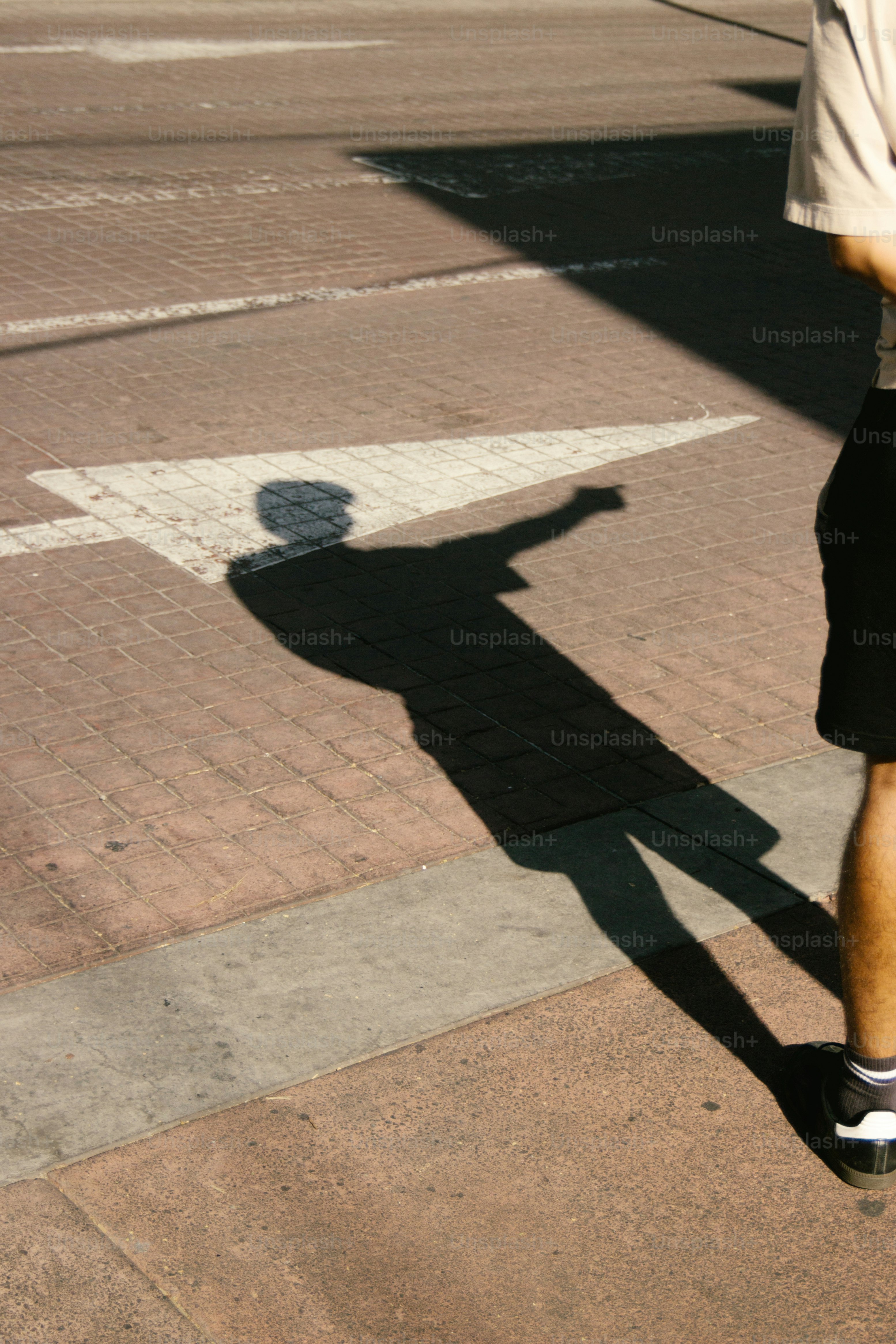 A shadow mimics a person pointing on the road. photo – Abstract Image ...