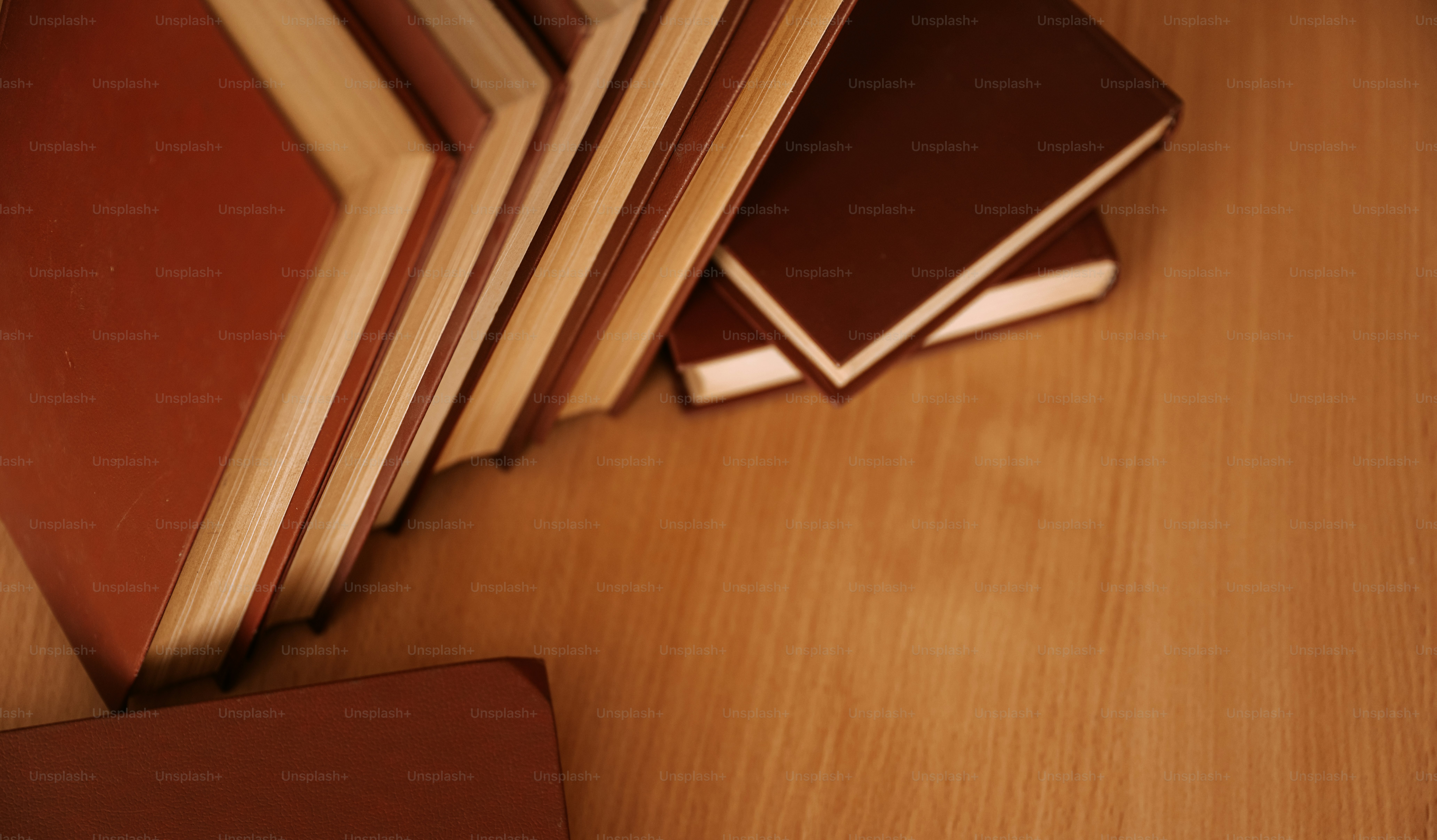 Books are stacked on a library table. photo – Green Image on Unsplash