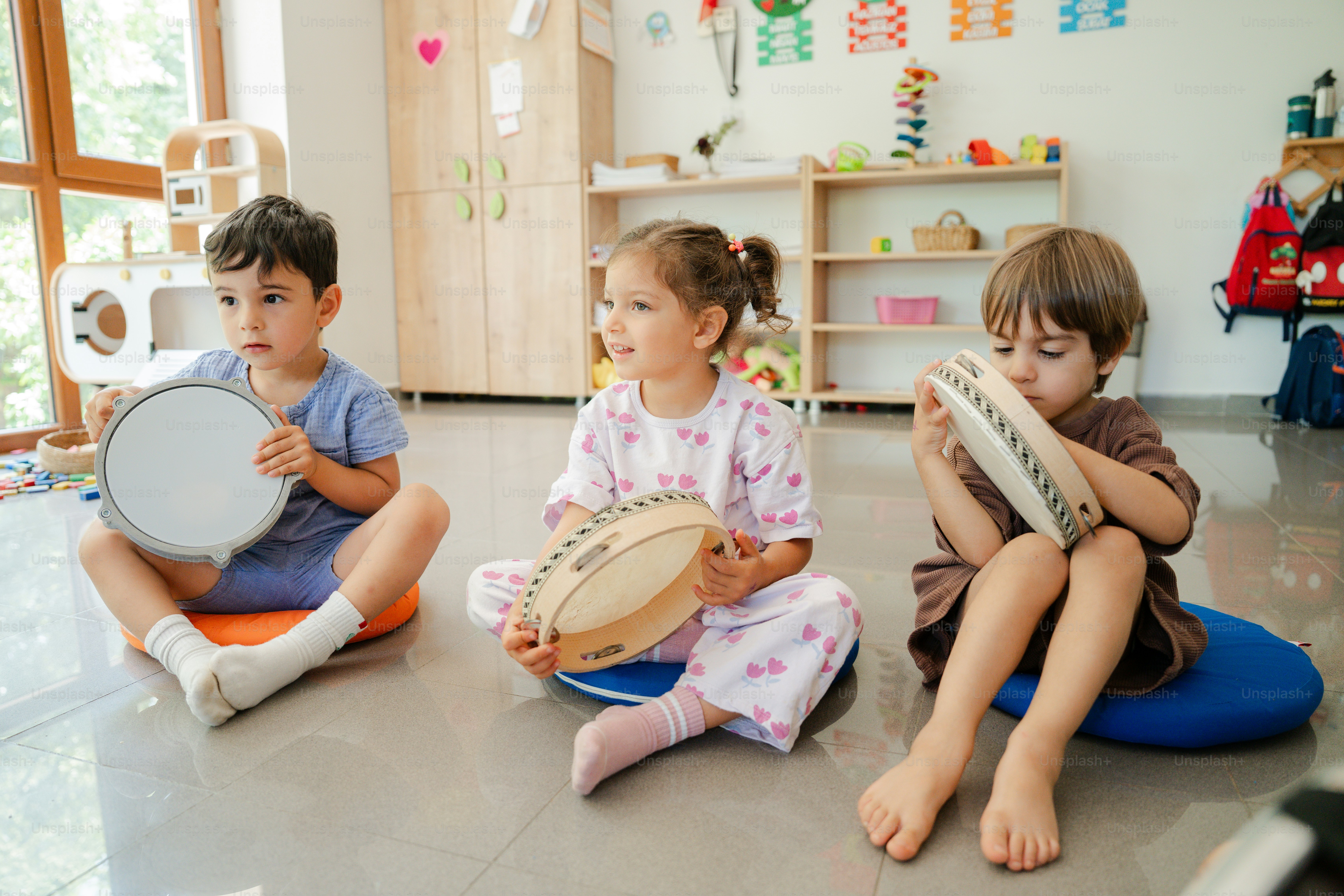 Children play tambourines in a classroom setting. photo – Kids Image on ...