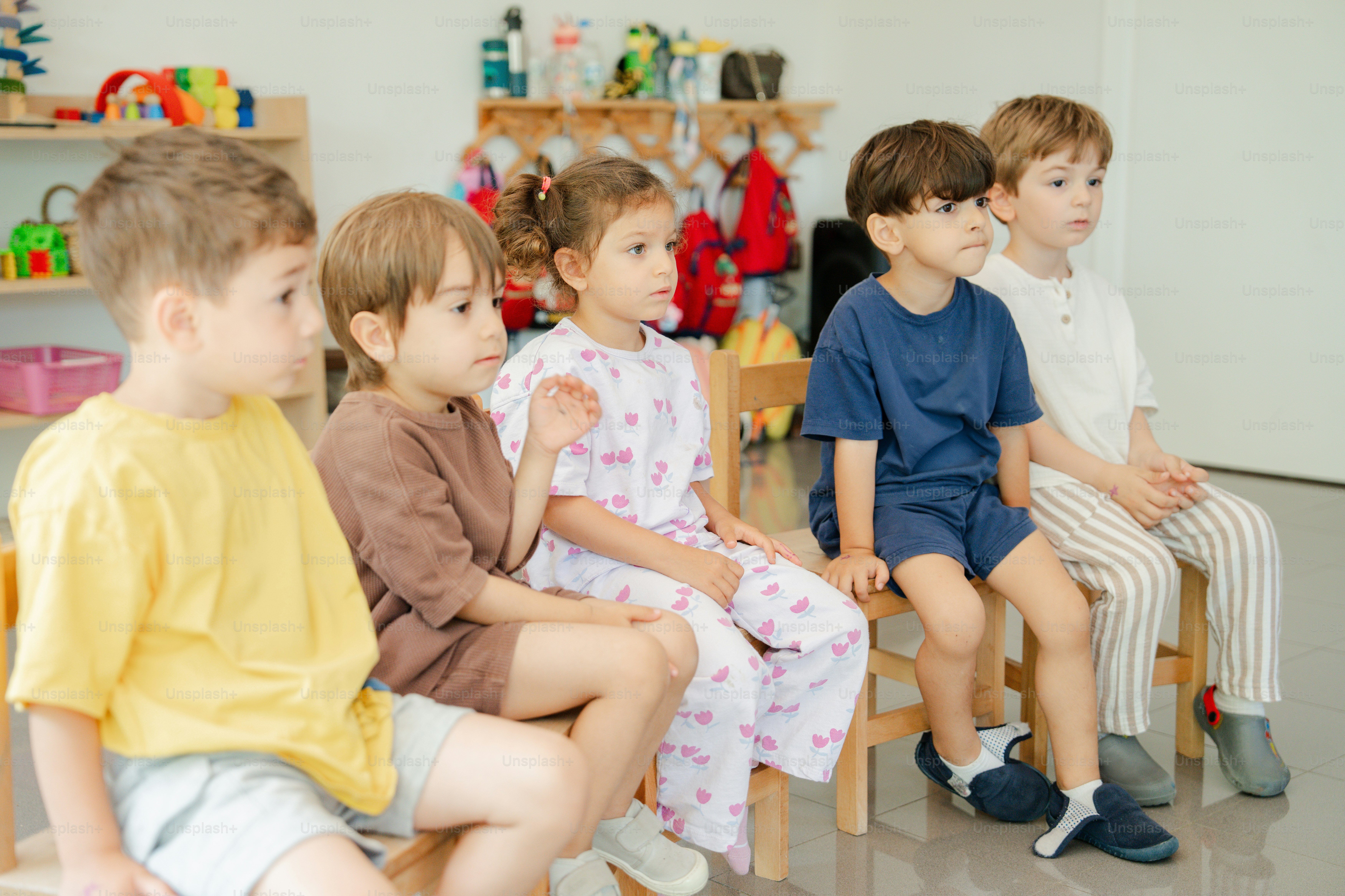 Children sit and watch something together. photo – Kids Image on Unsplash