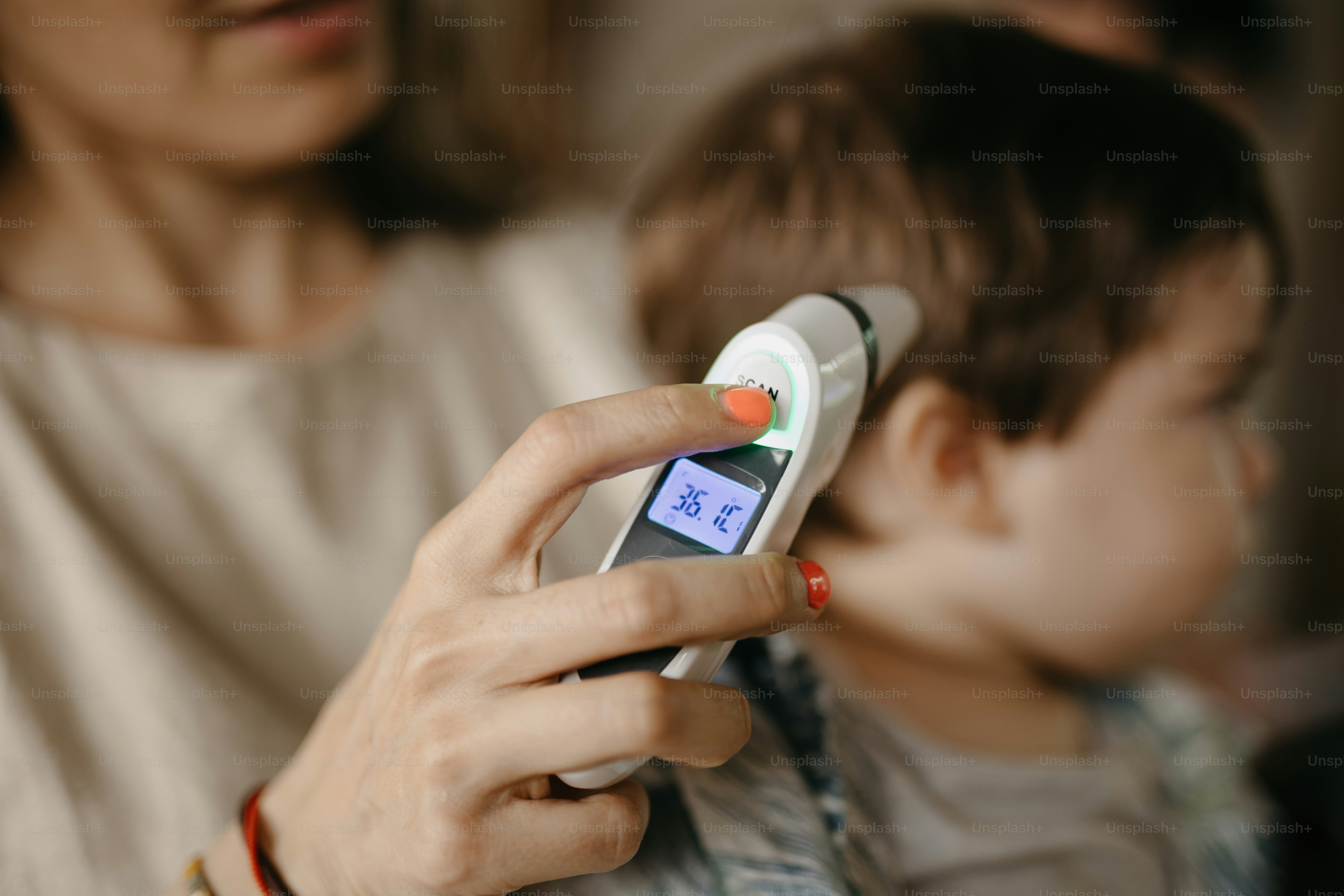 A parent measures baby's temperature with thermometer. photo ...