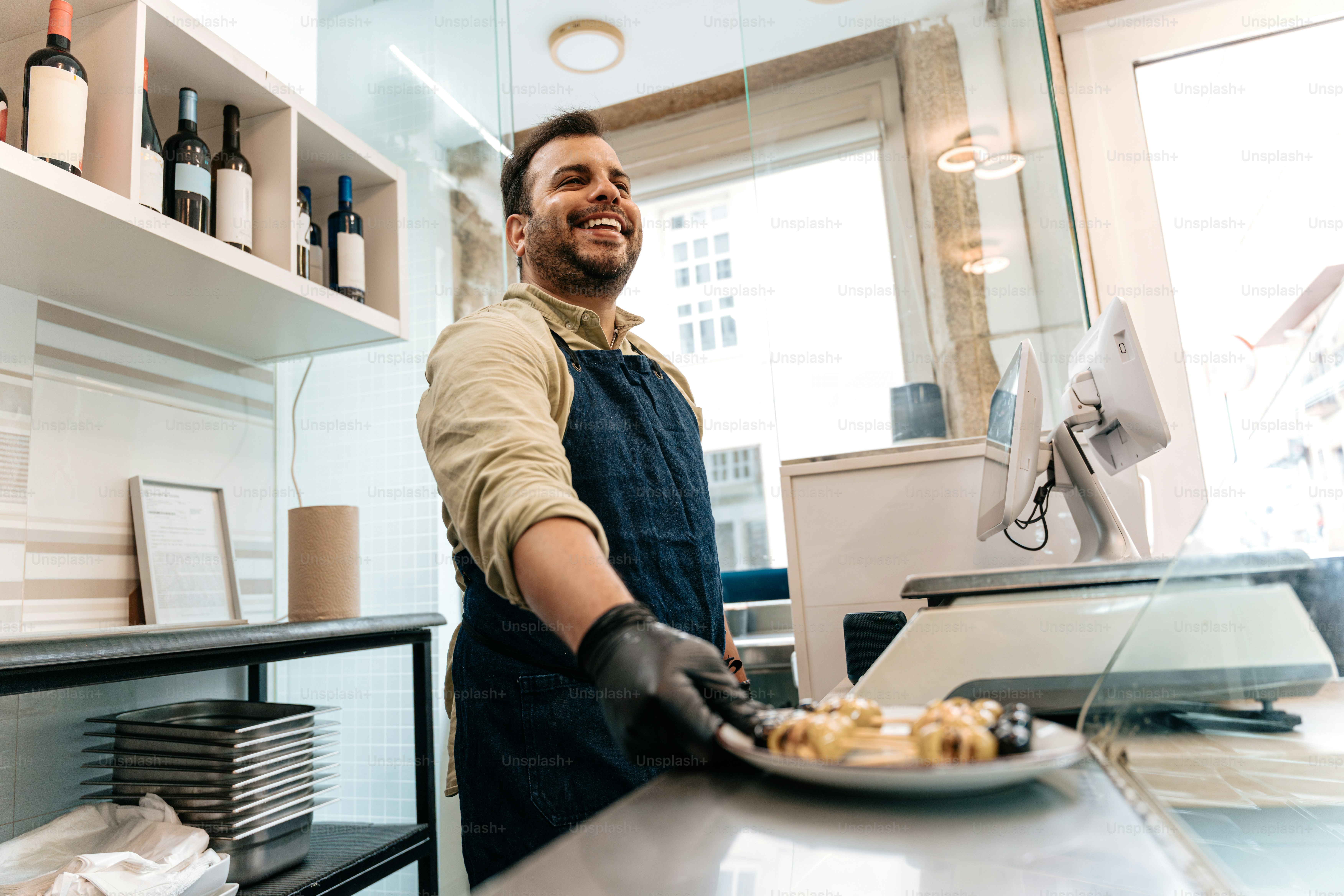 A chef happily serves a plate of food. photo – Restaurant Image on Unsplash