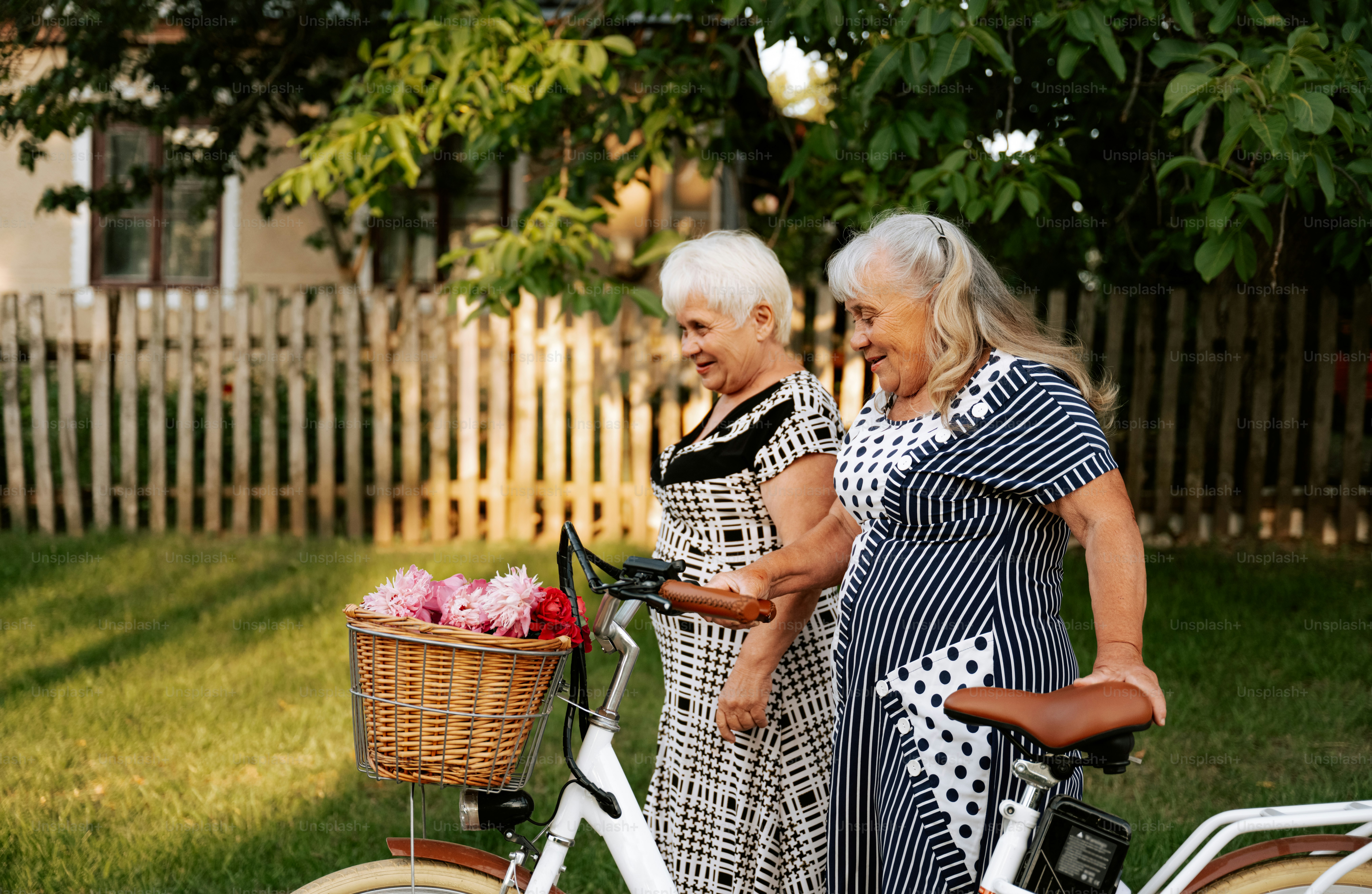 Two elderly women walk with a bicycle. photo – Friends Image on Unsplash