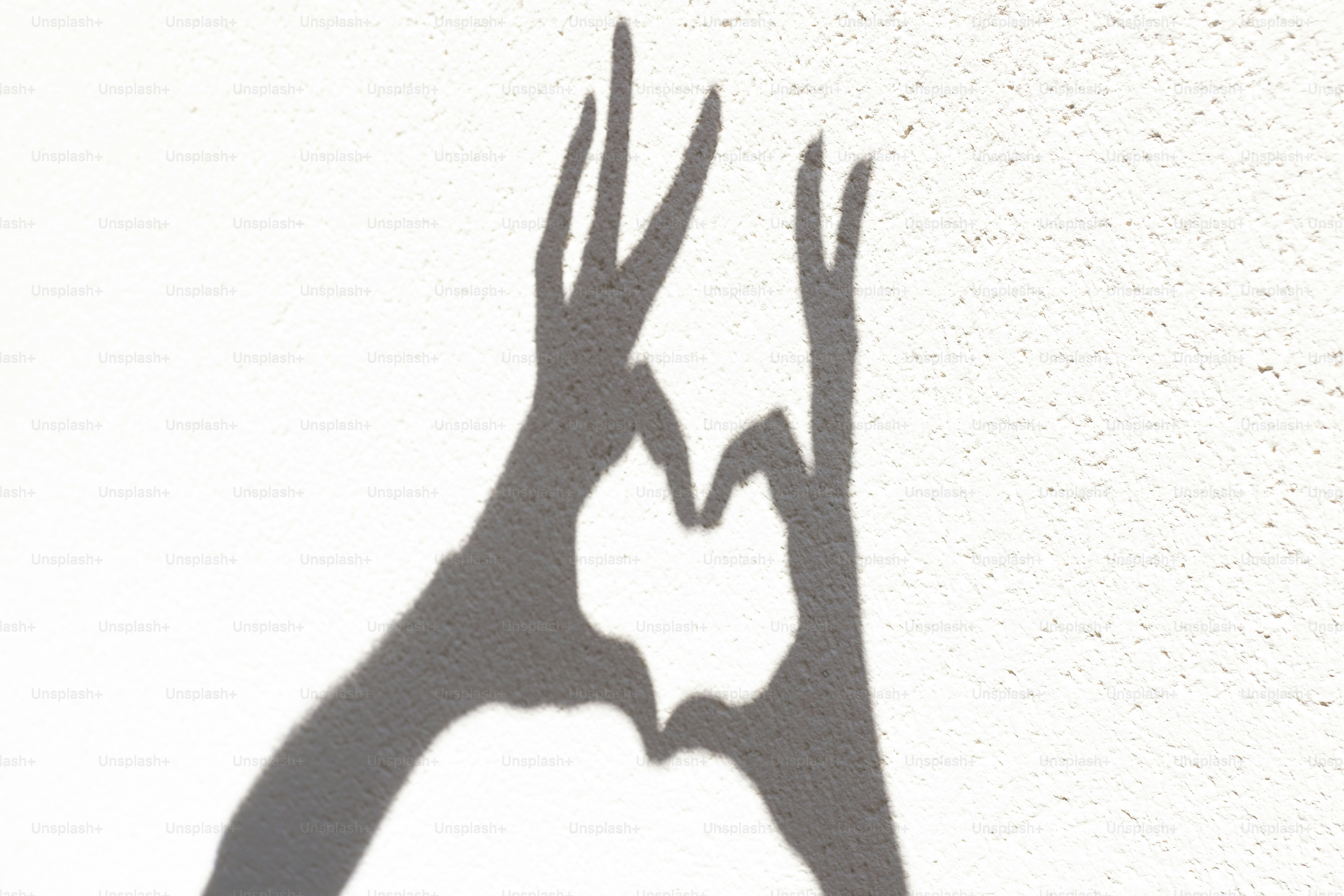 A shadow shows hands forming a heart. photo – Abstract Image on Unsplash