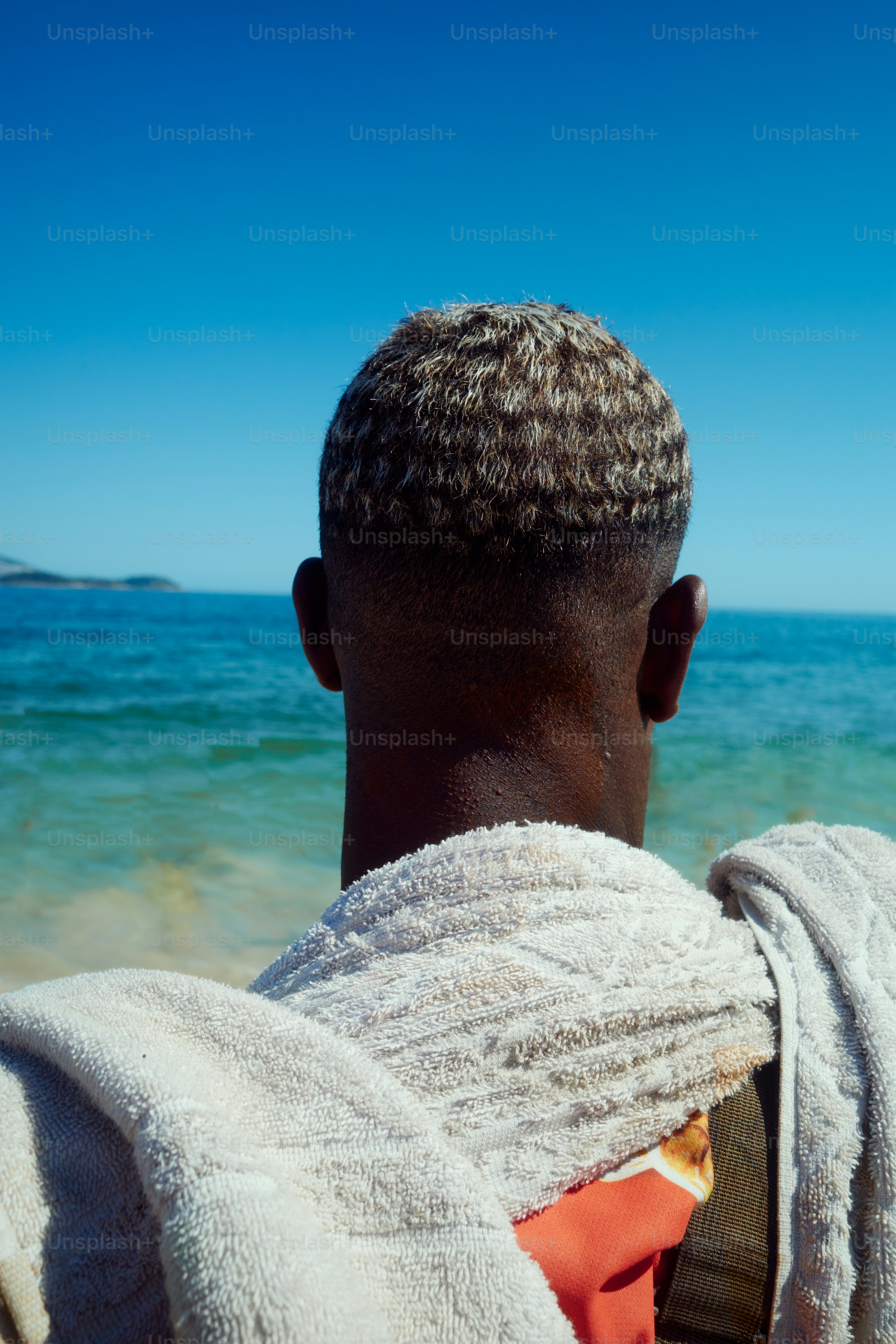 Man looks out at the beach and ocean. photo – Portrait Image on Unsplash