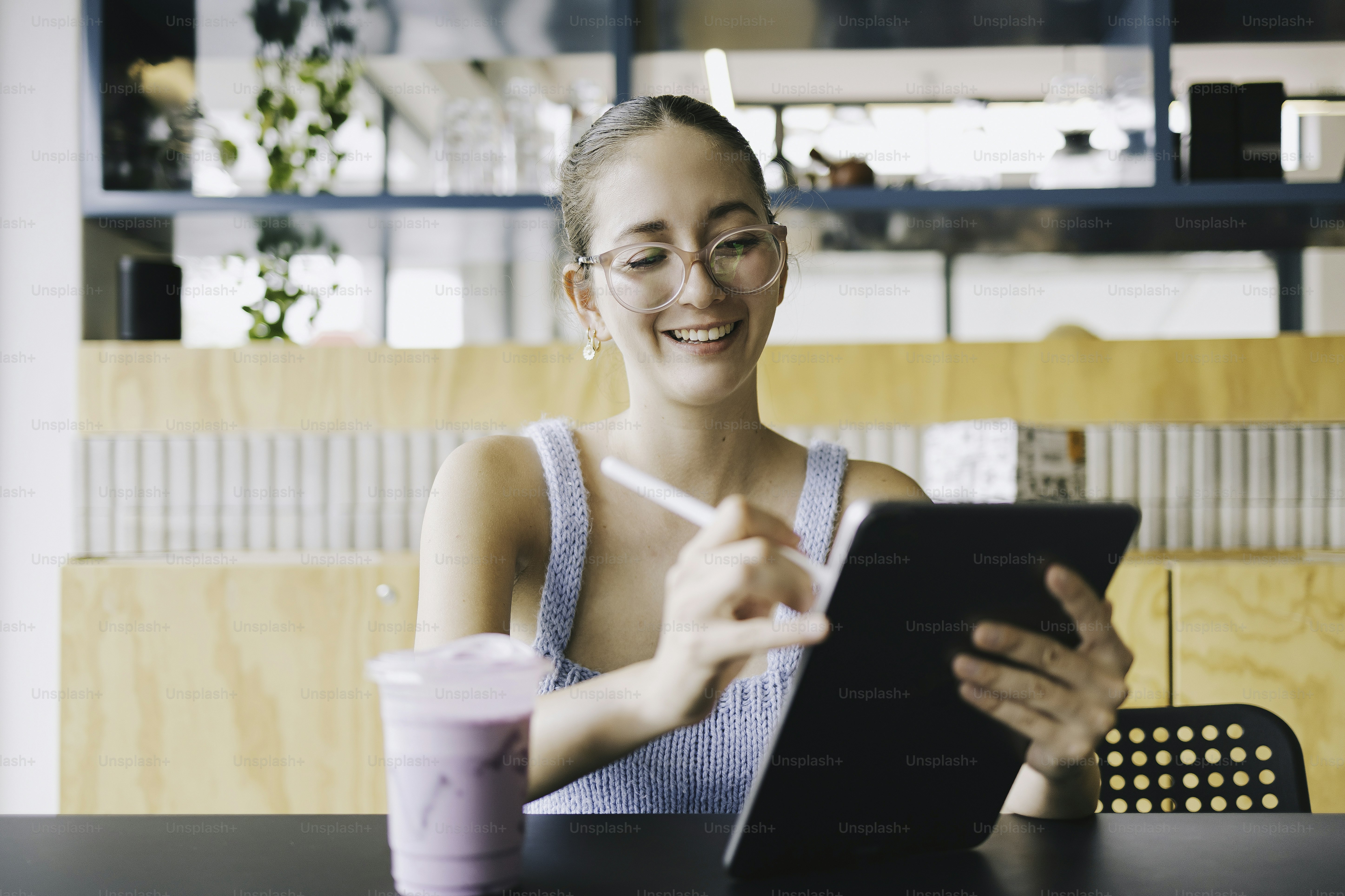 A woman smiles while using a tablet. photo – Technology Image on Unsplash
