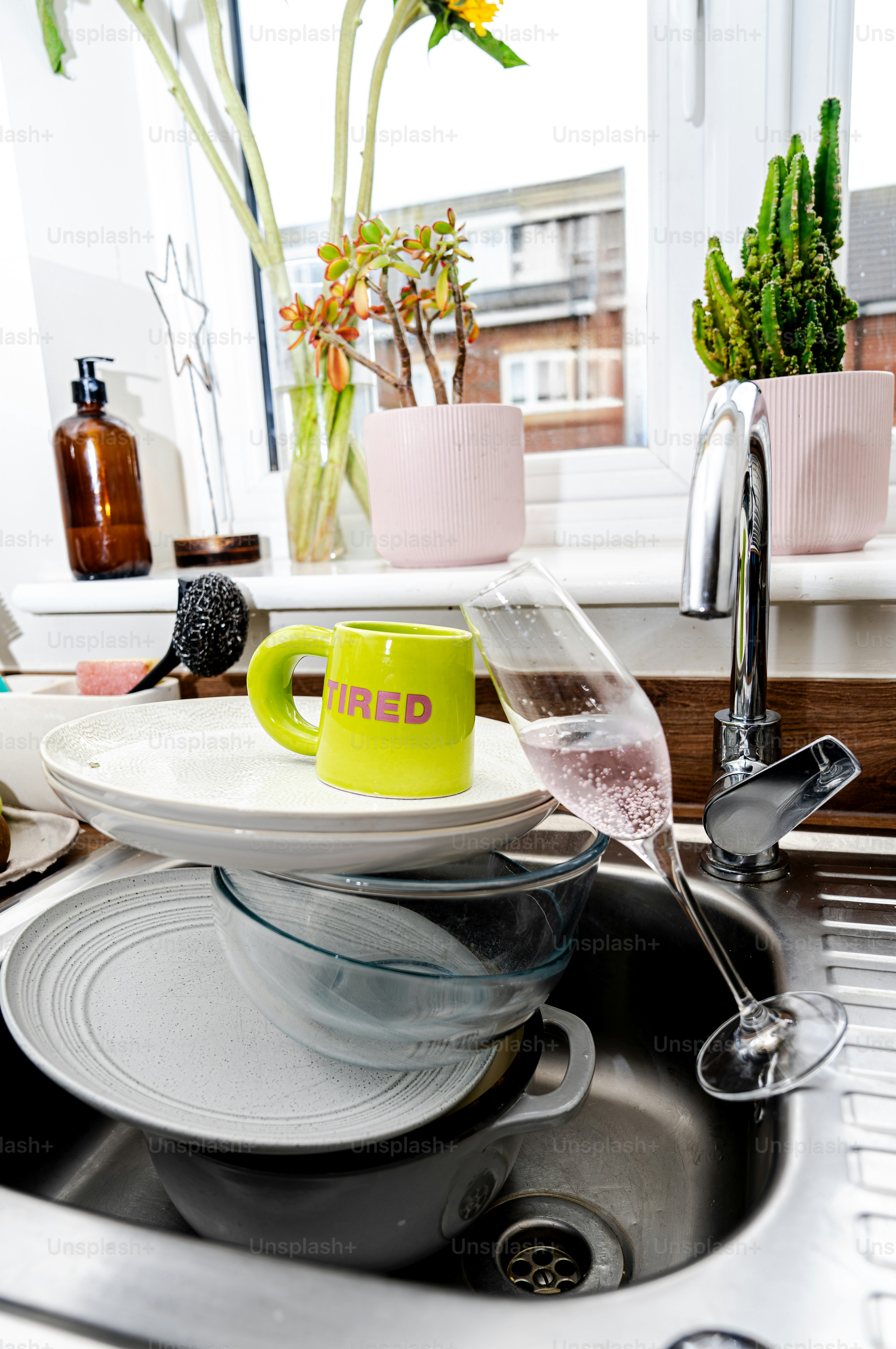 Sink full of dirty dishes needs washing. photo – Flash Image on Unsplash