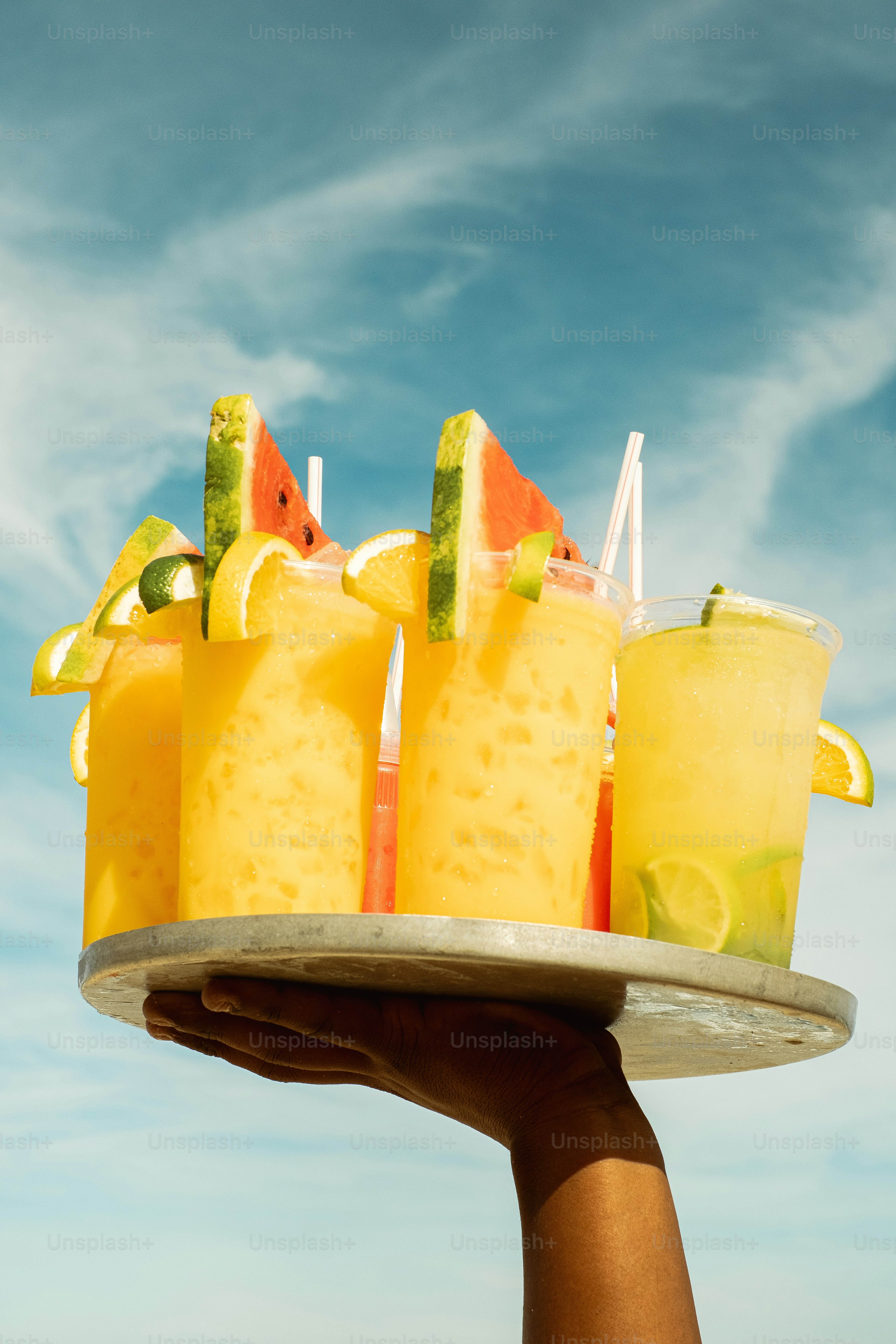 Fresh fruit juices are served on a tray. photo – Summer Image on Unsplash