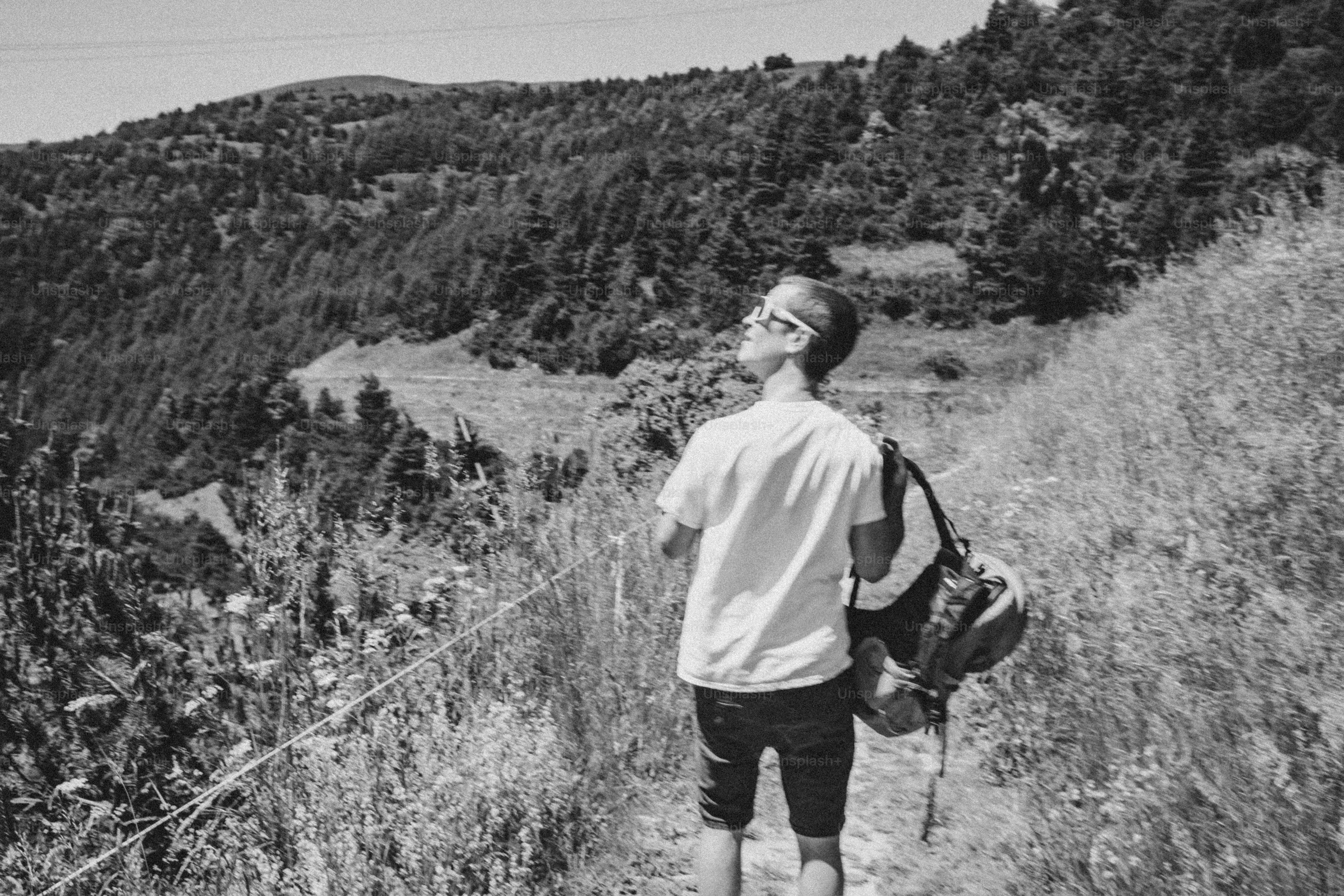 A person hikes up a hill and admire the view. photo – Mountains Image ...