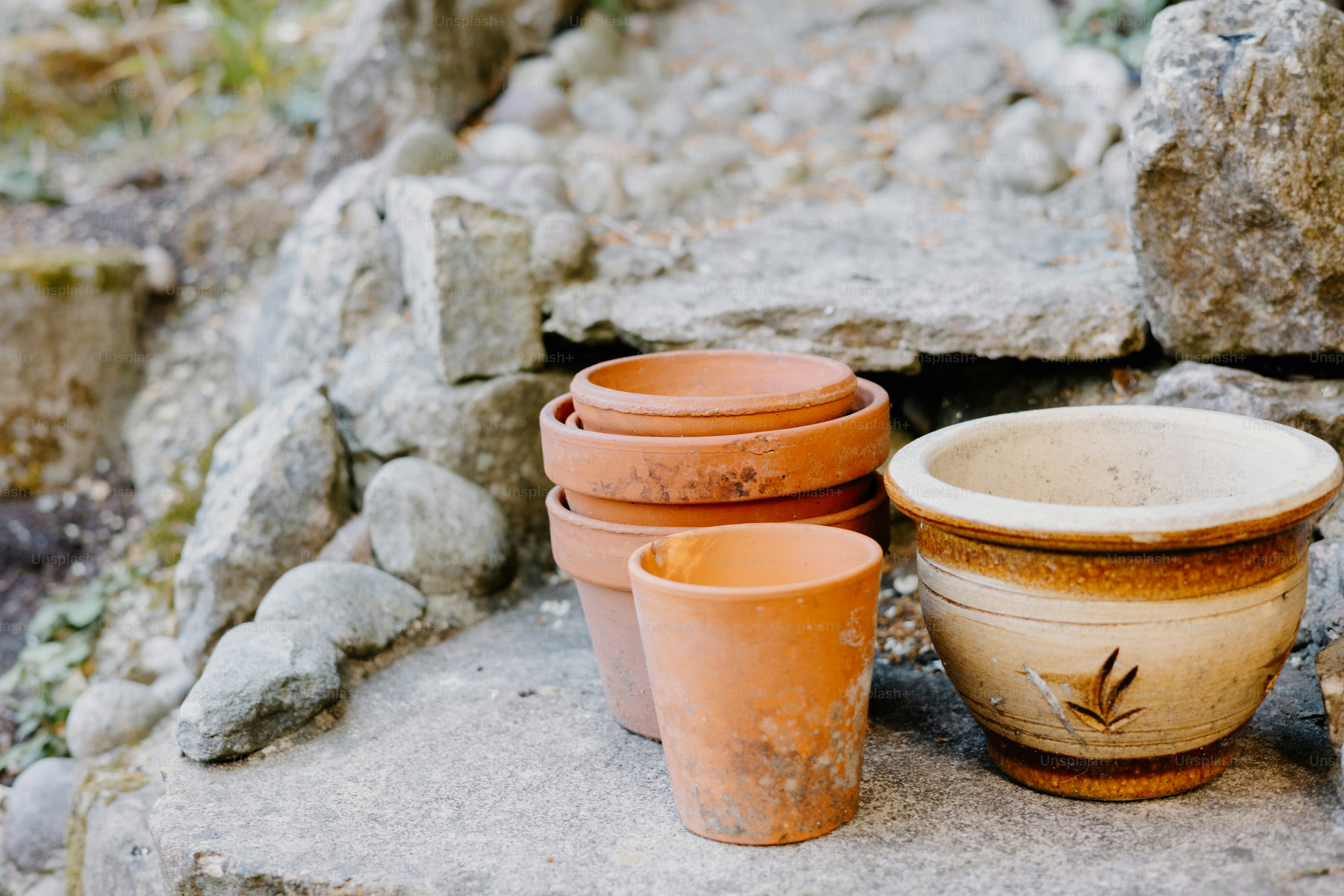 Pots rest on a stone wall. photo – Pots Image on Unsplash