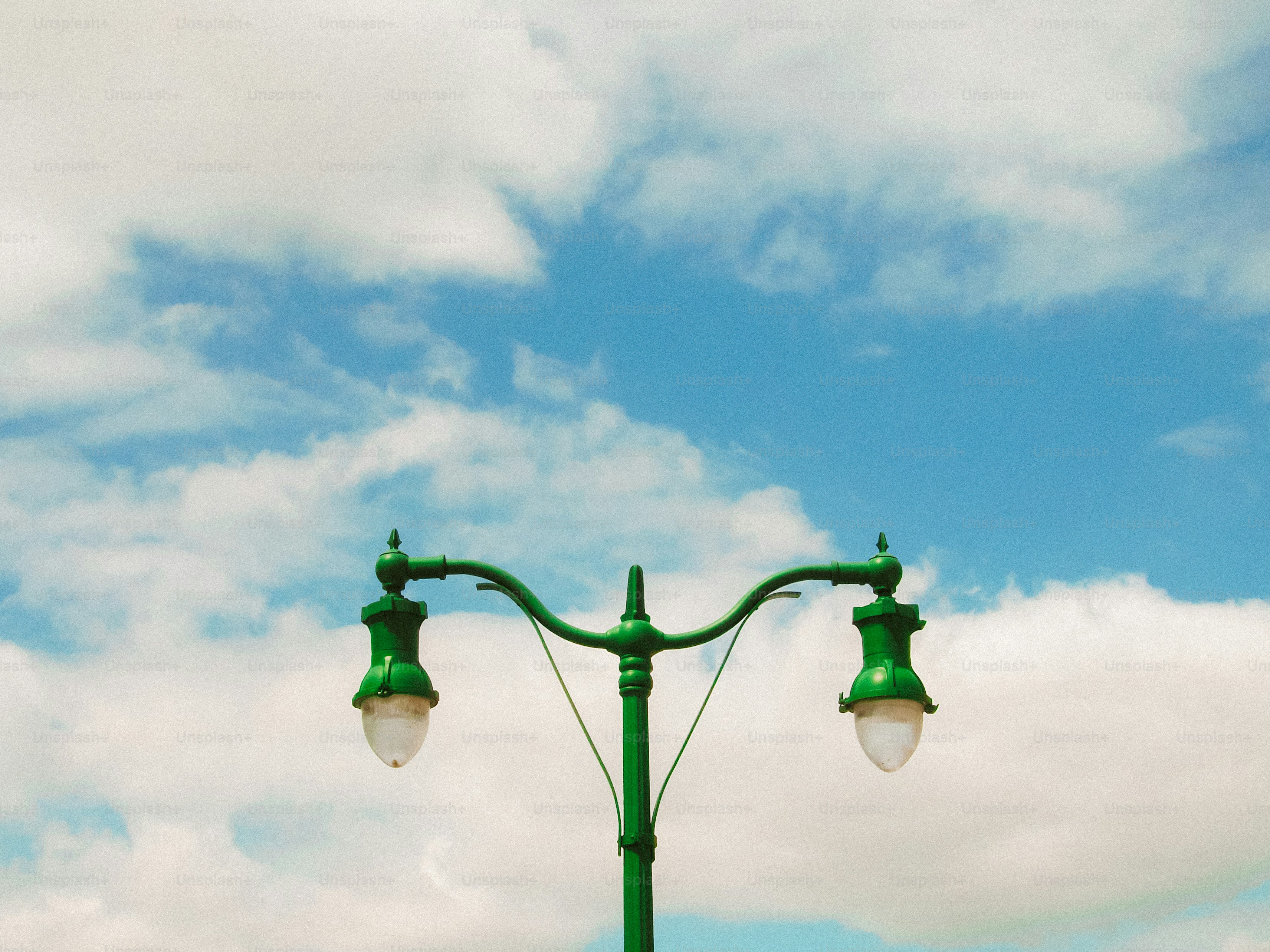 Green lamppost against a cloudy, blue sky. photo – Architecture Image ...
