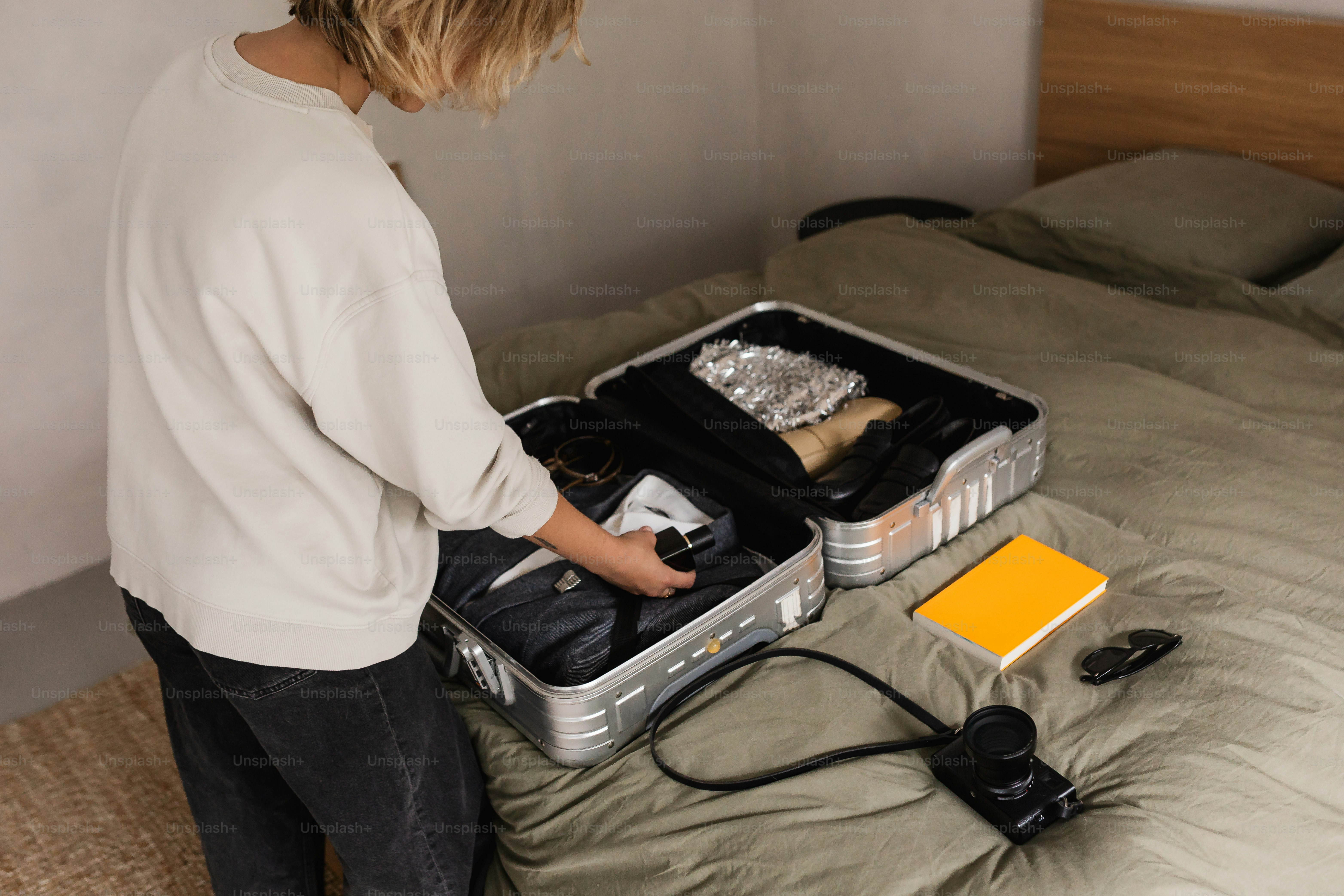 Someone is packing a suitcase on a bed. photo – Travel Image on Unsplash