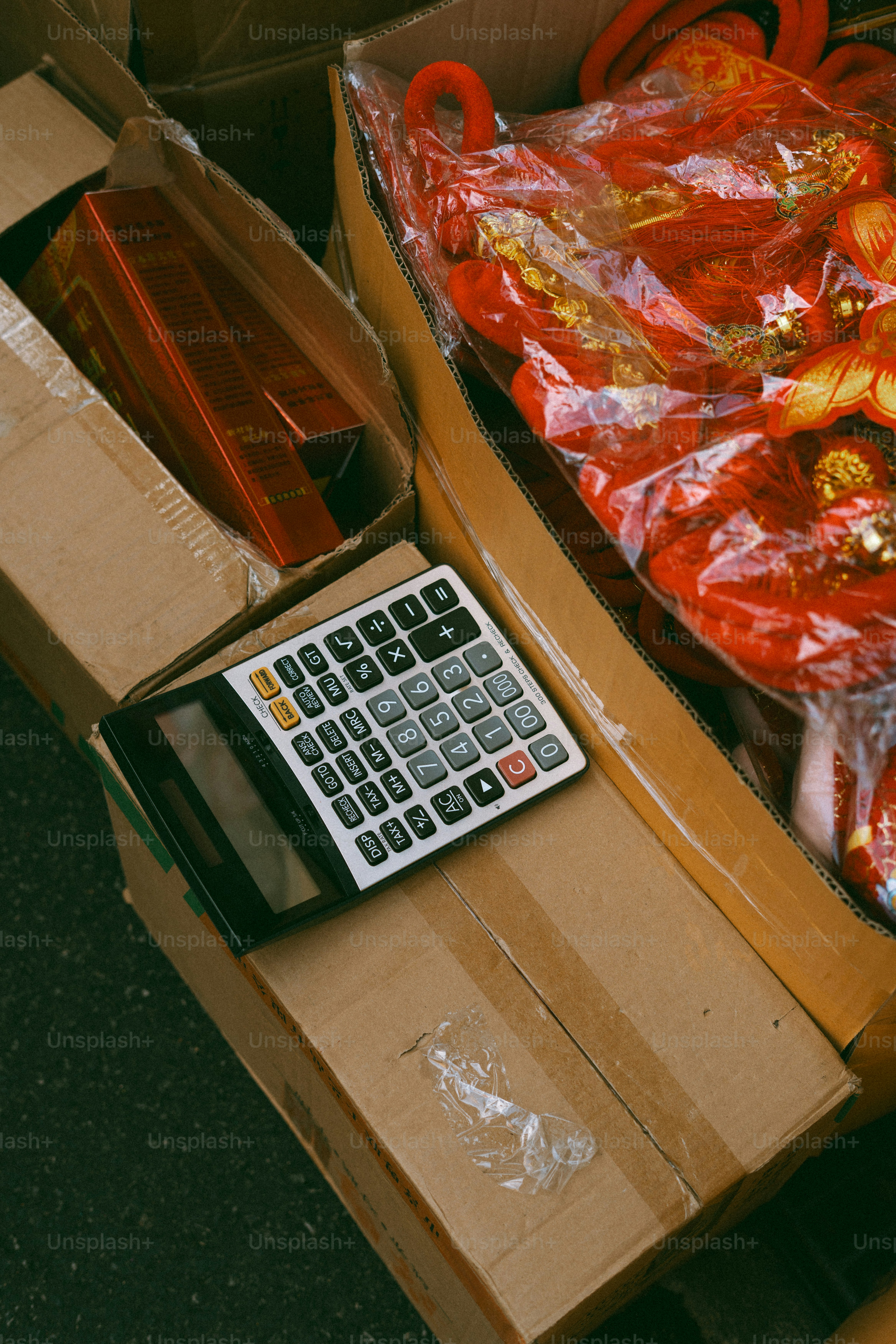 A calculator sits among boxes of decorative items. photo – Travel Image ...