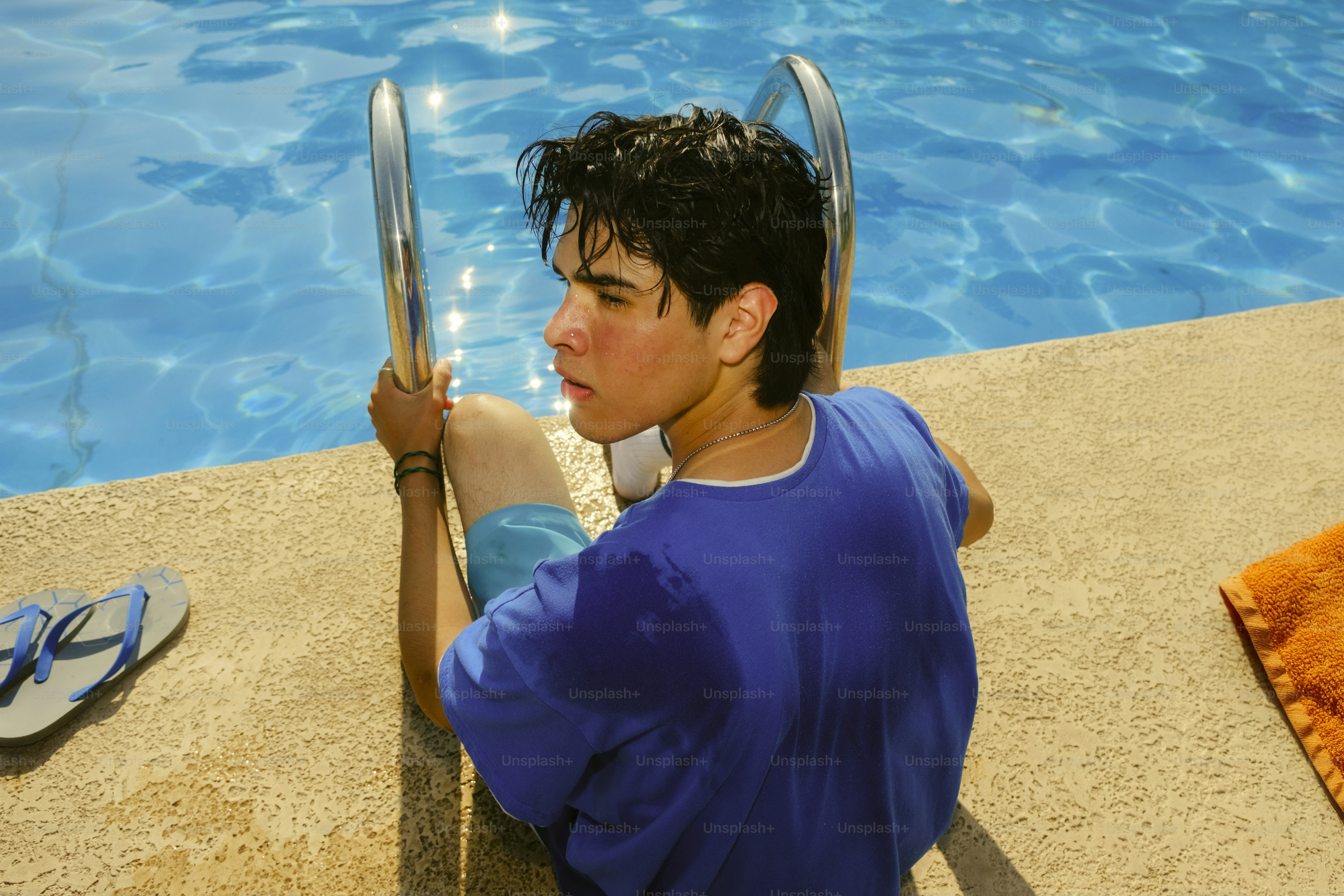 A wet teenager exits the pool. photo – Summer Image on Unsplash