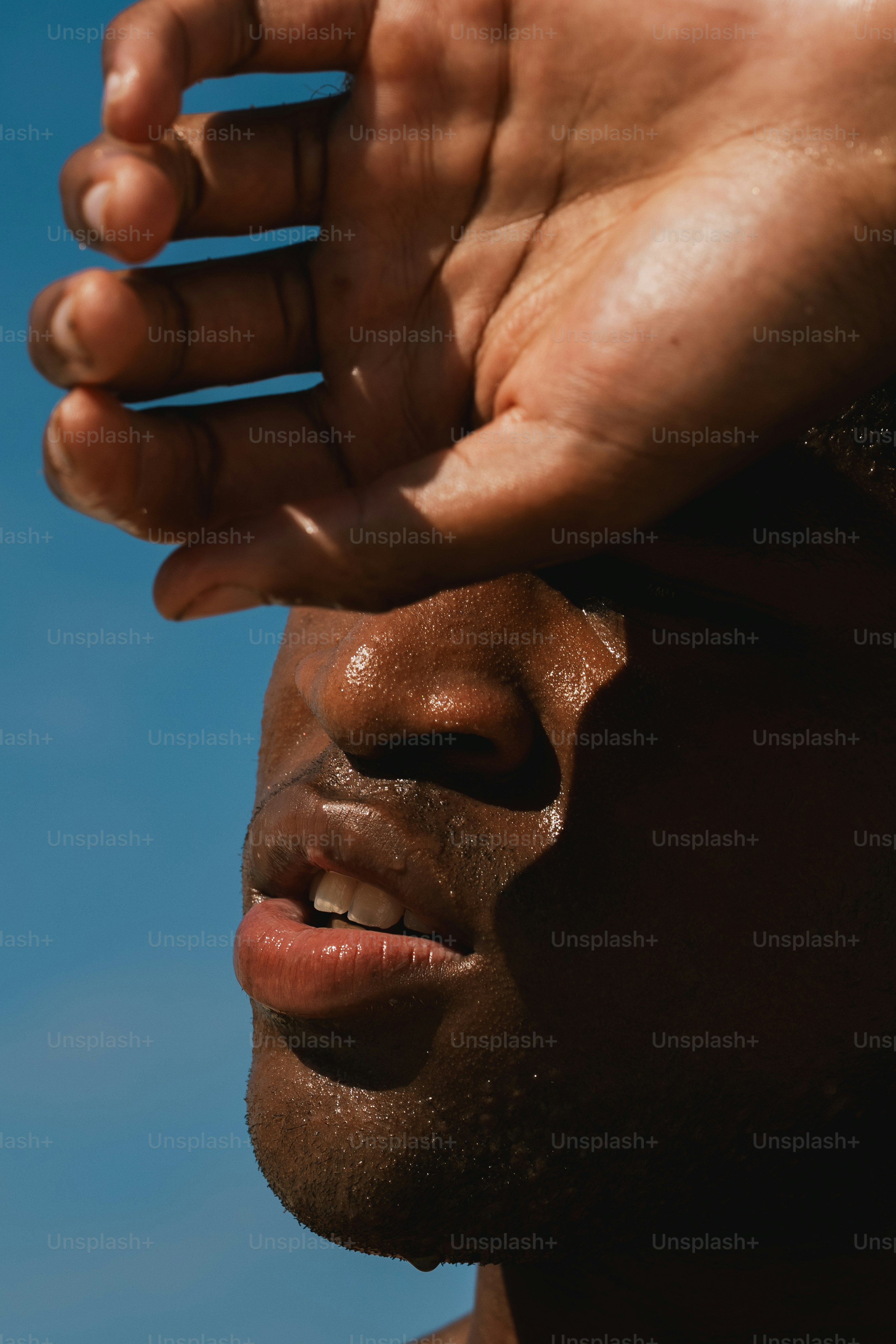 Man shields his face from the sun with his hand. photo – Summer Image ...