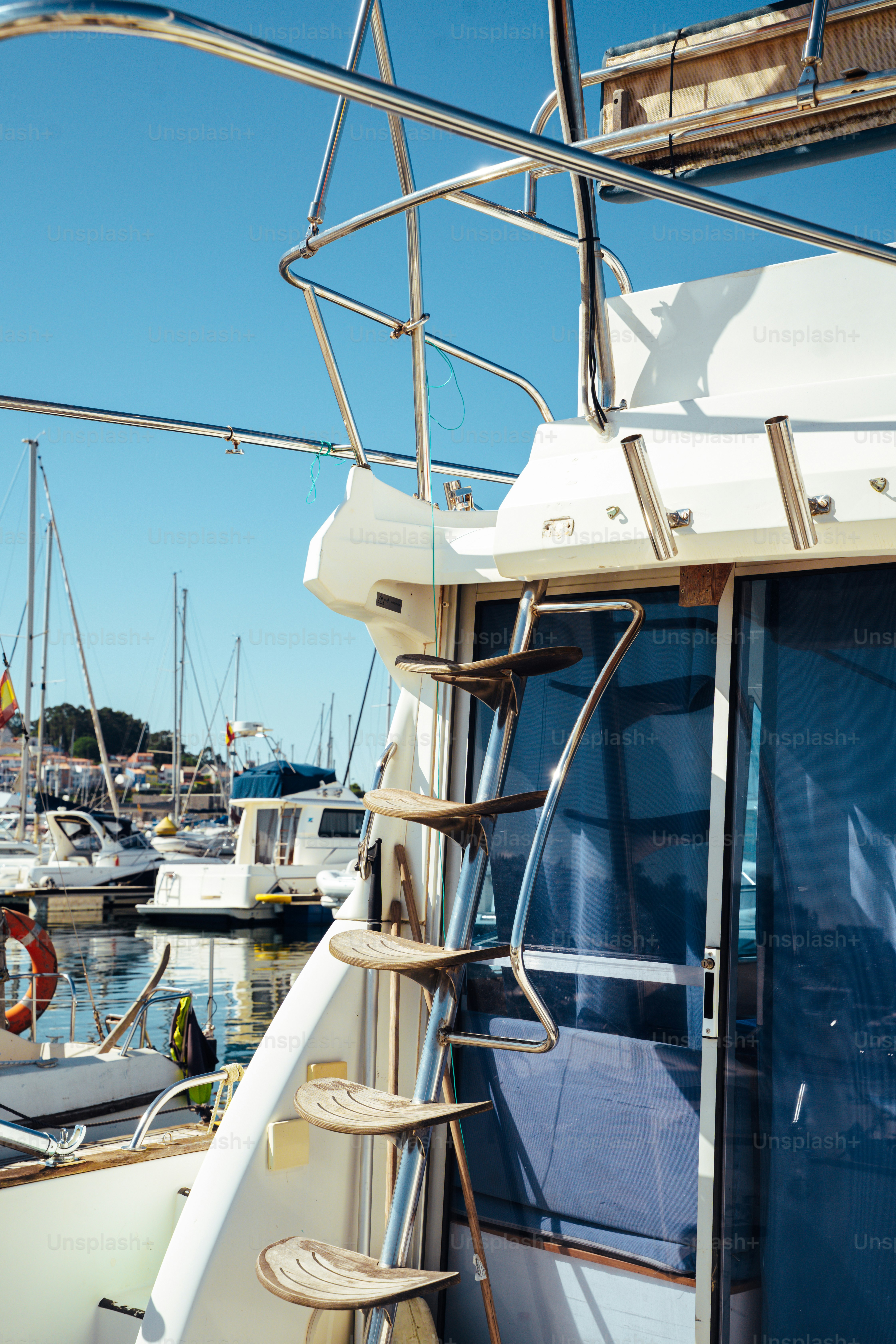A boat with stairs and other boats in a harbor. photo – Boating Image ...