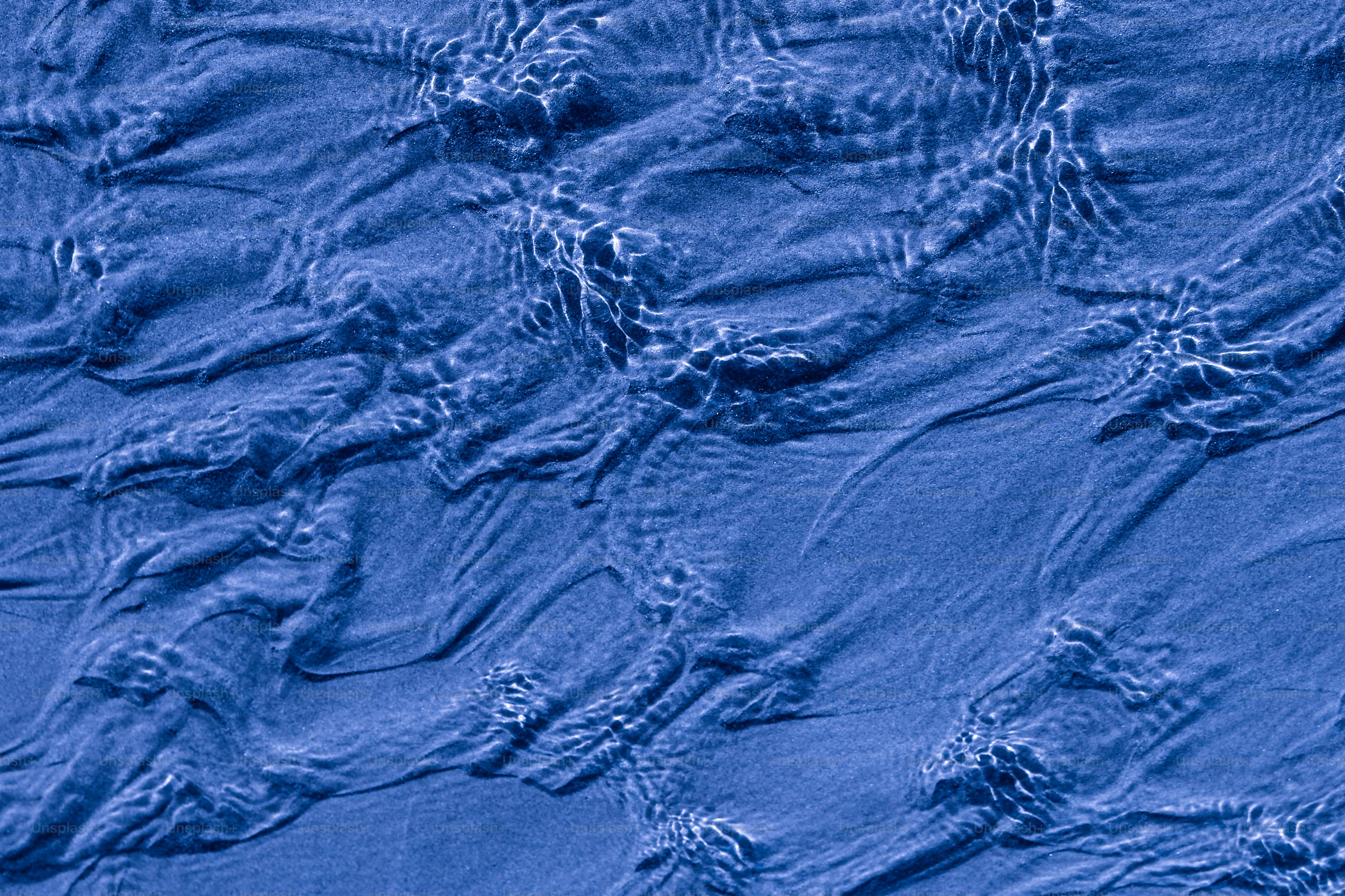 Water flows across a blue surface. photo – Wallpaper Image on Unsplash