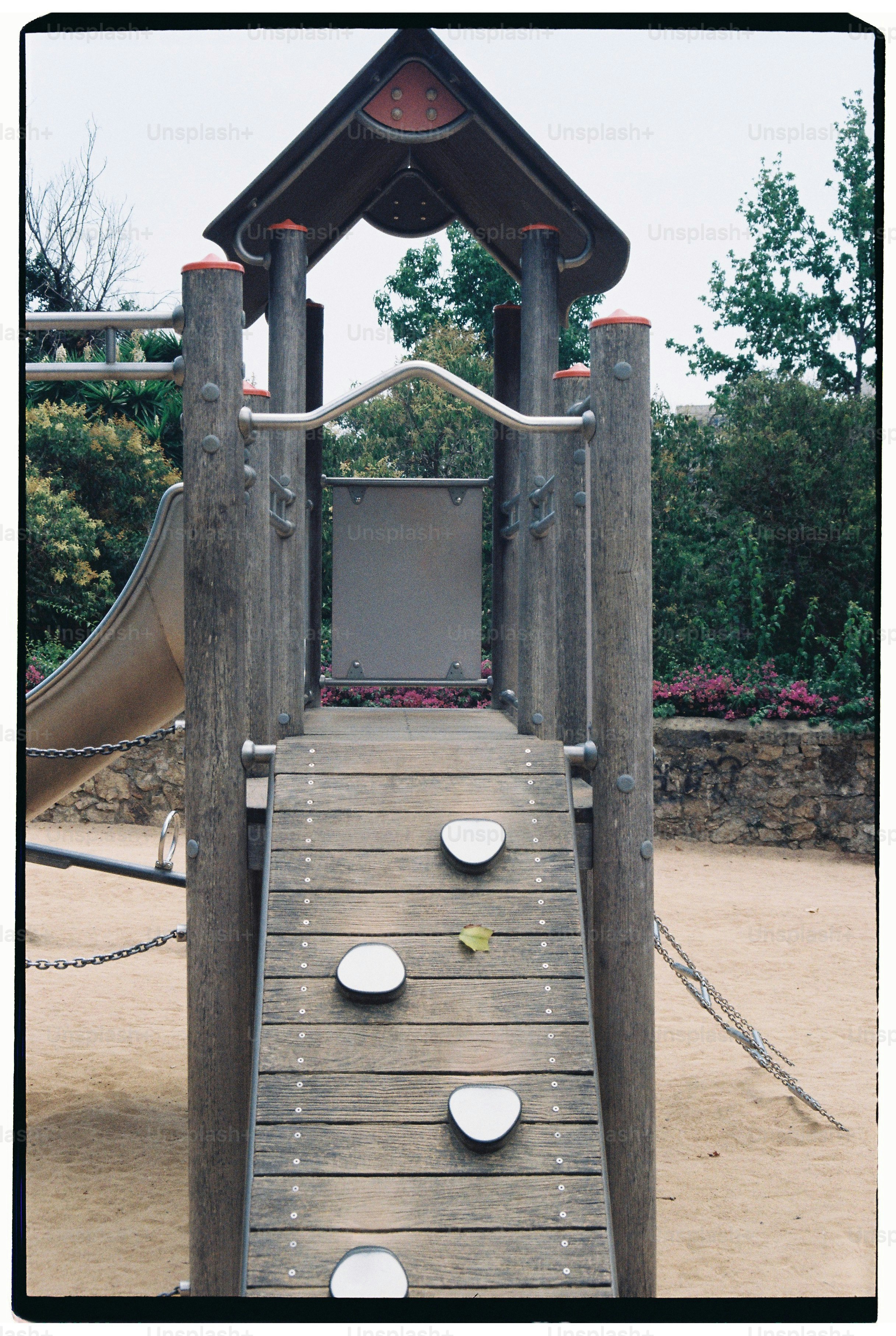 A wooden playground structure stands ready for fun. photo – Film Image ...