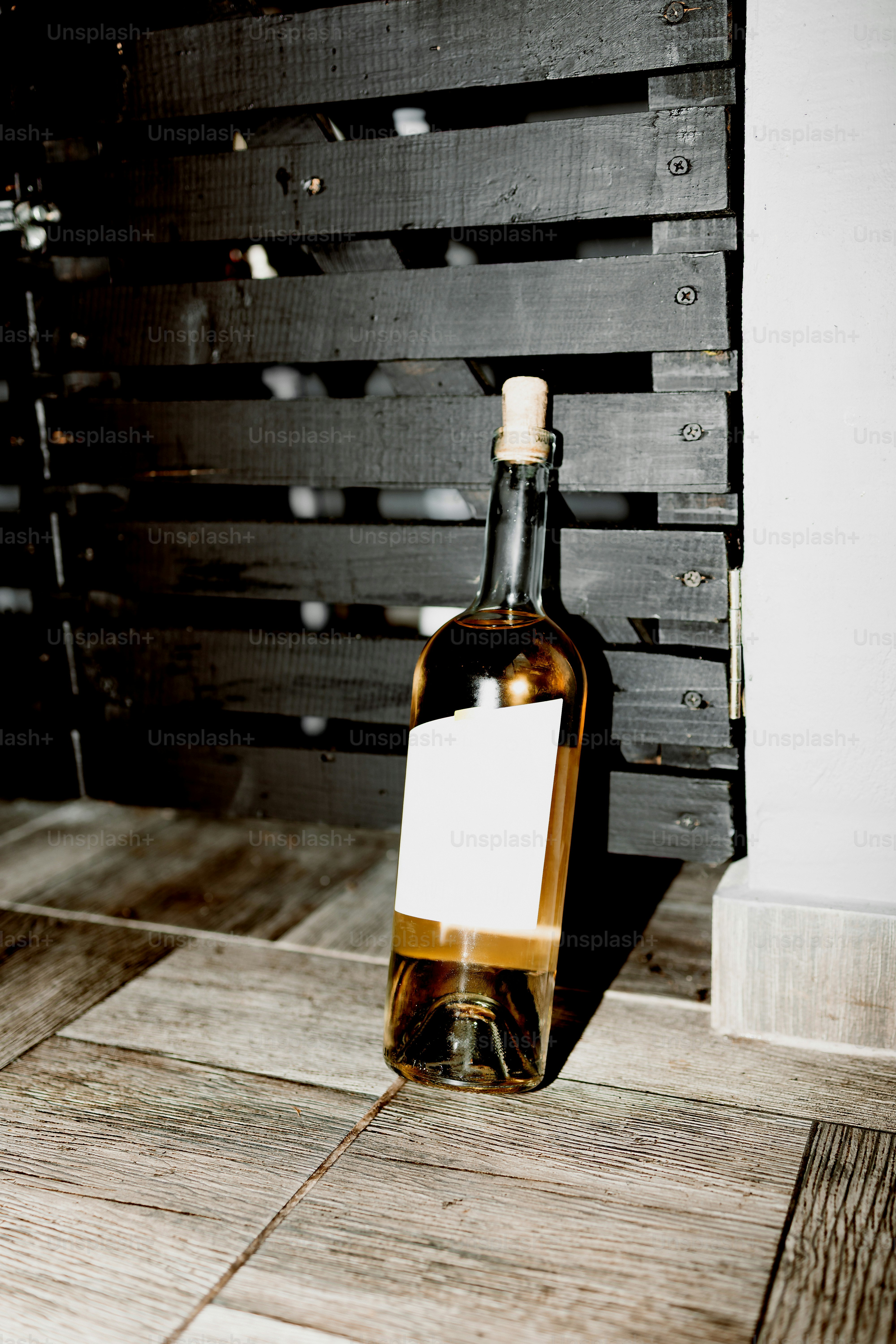 A bottle of wine stands on the floor. photo – Natural Image on Unsplash
