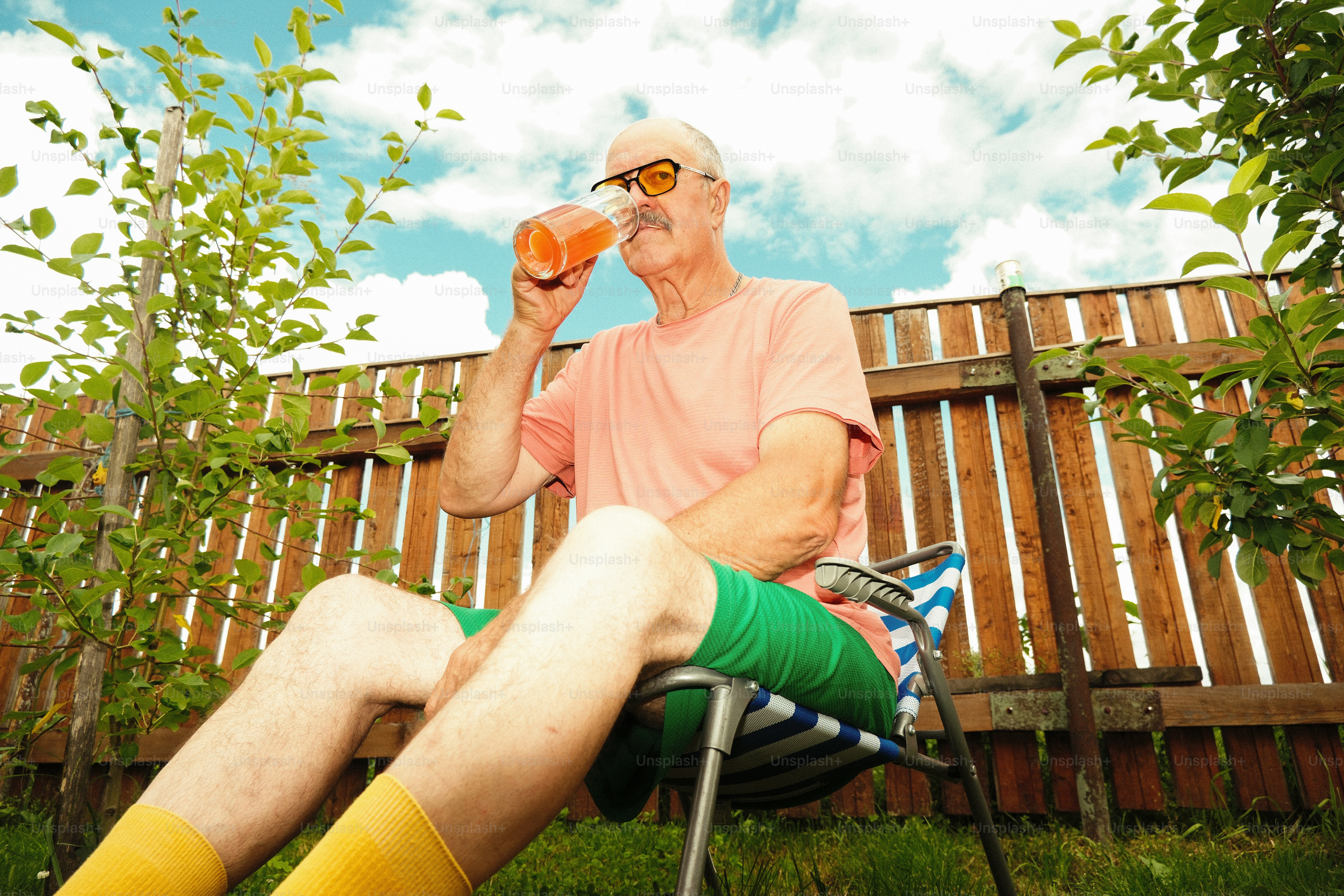 Man drinks juice in the backyard. photo – Blue Image on Unsplash