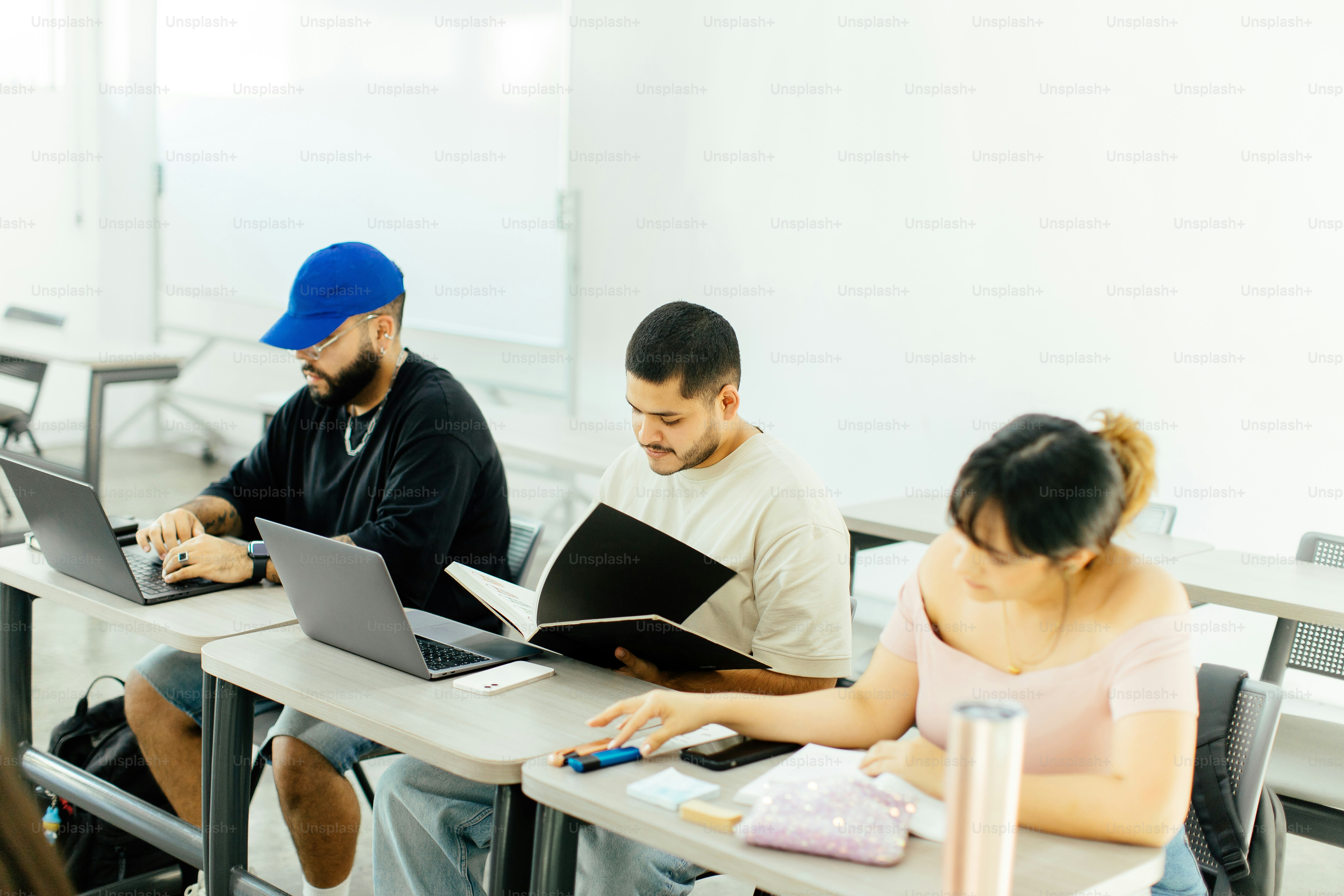 Students studying in a classroom with laptops and books. photo – School ...