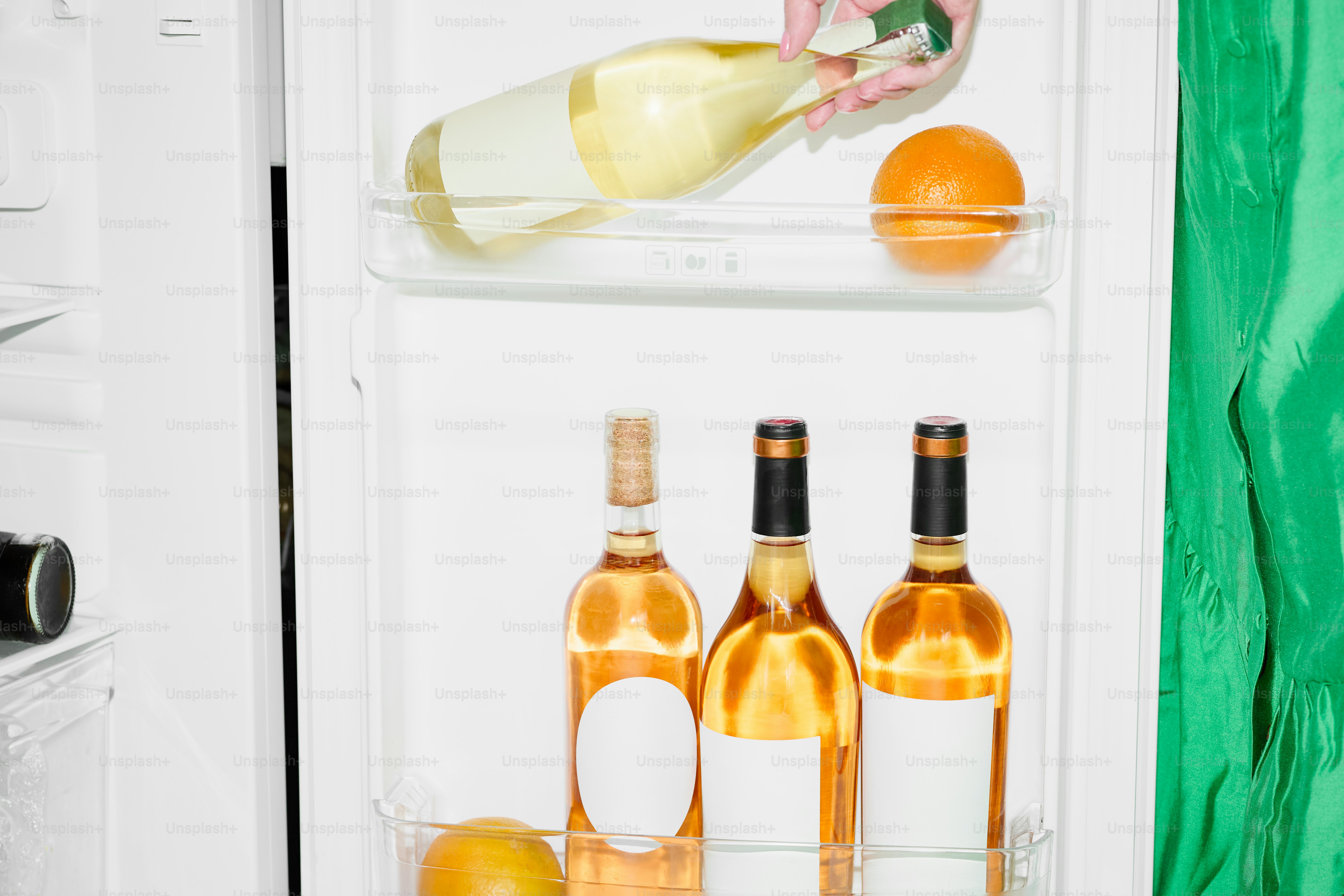Wine bottles and an orange chill inside the fridge. photo – Natural ...