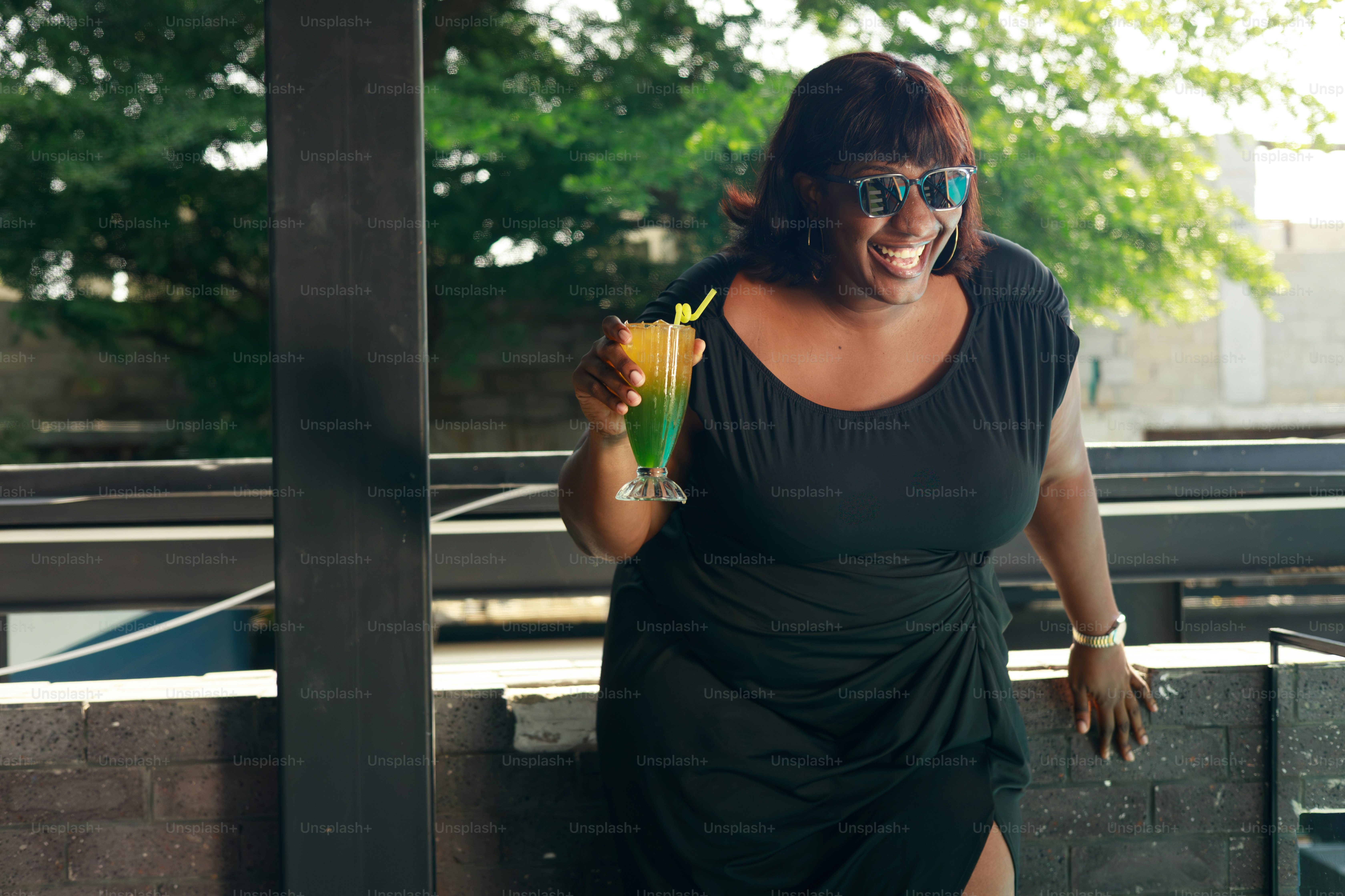 Woman cheers with a cocktail, smiling at the camera. photo – Diversity ...