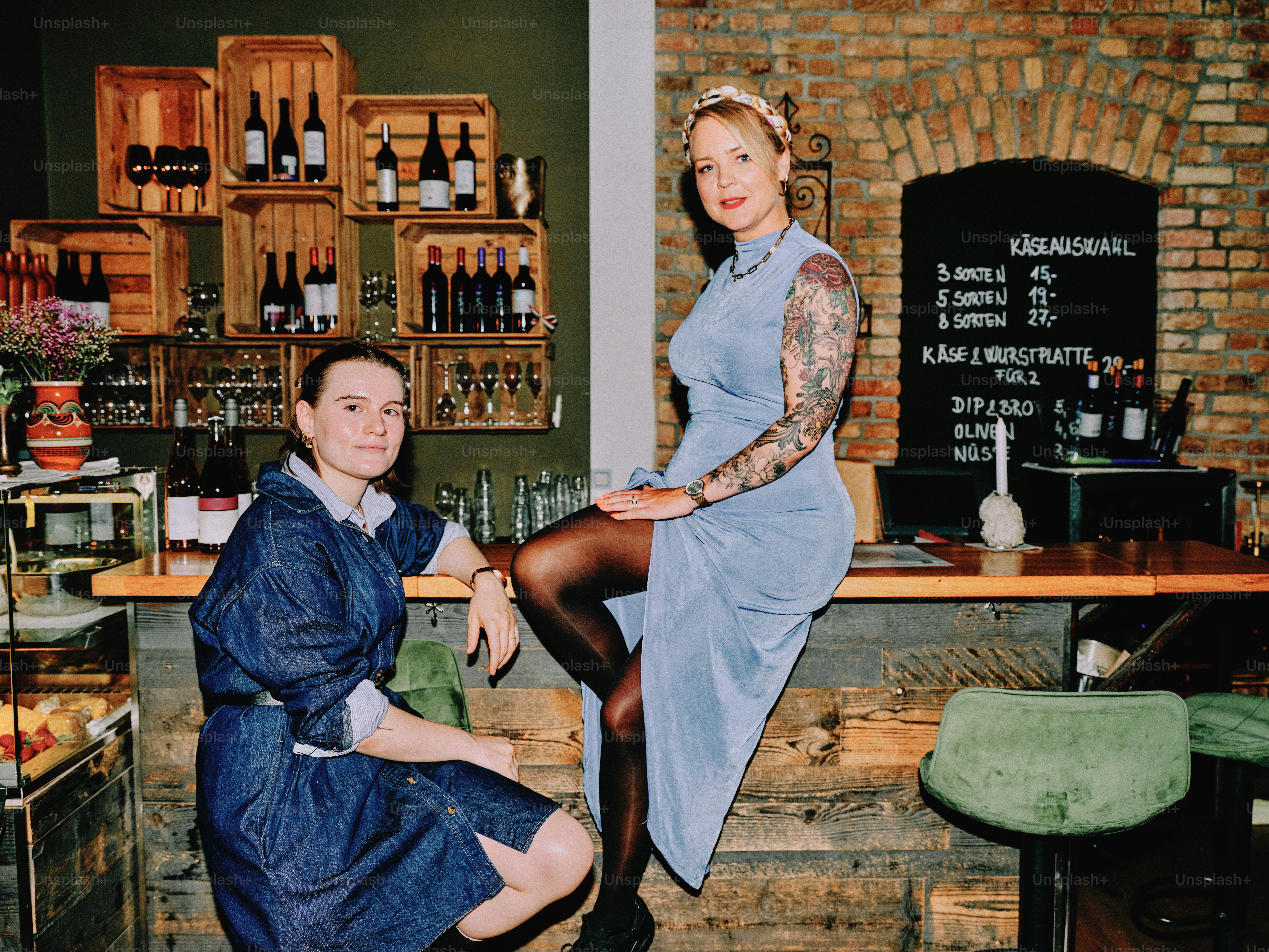 Two women pose at a stylish bar. photo – Wine Image on Unsplash