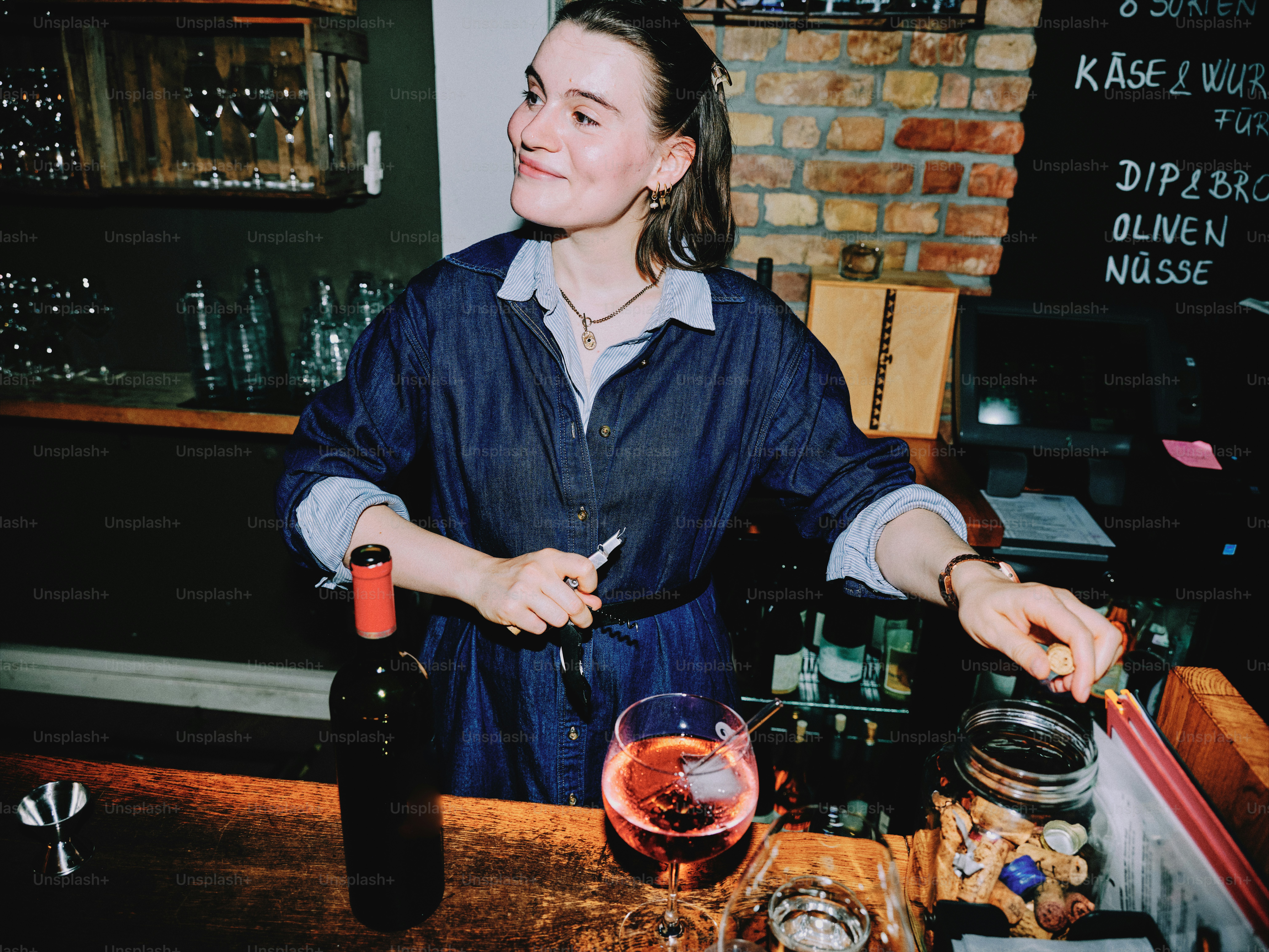 A bartender smiles while preparing a drink. photo – Bar Image on Unsplash