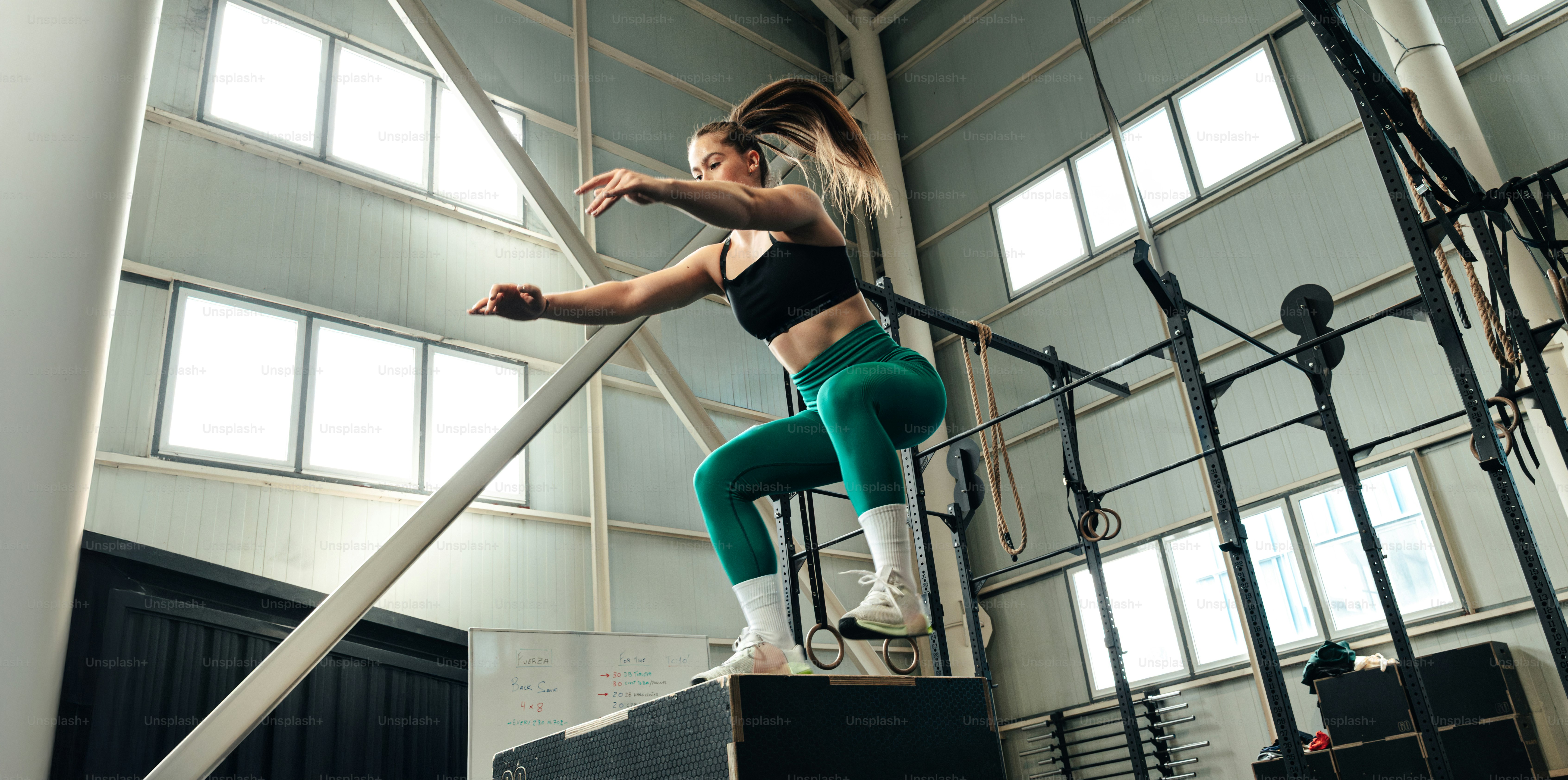 A woman jumps onto a box during a workout. photo – Exercise Image on ...