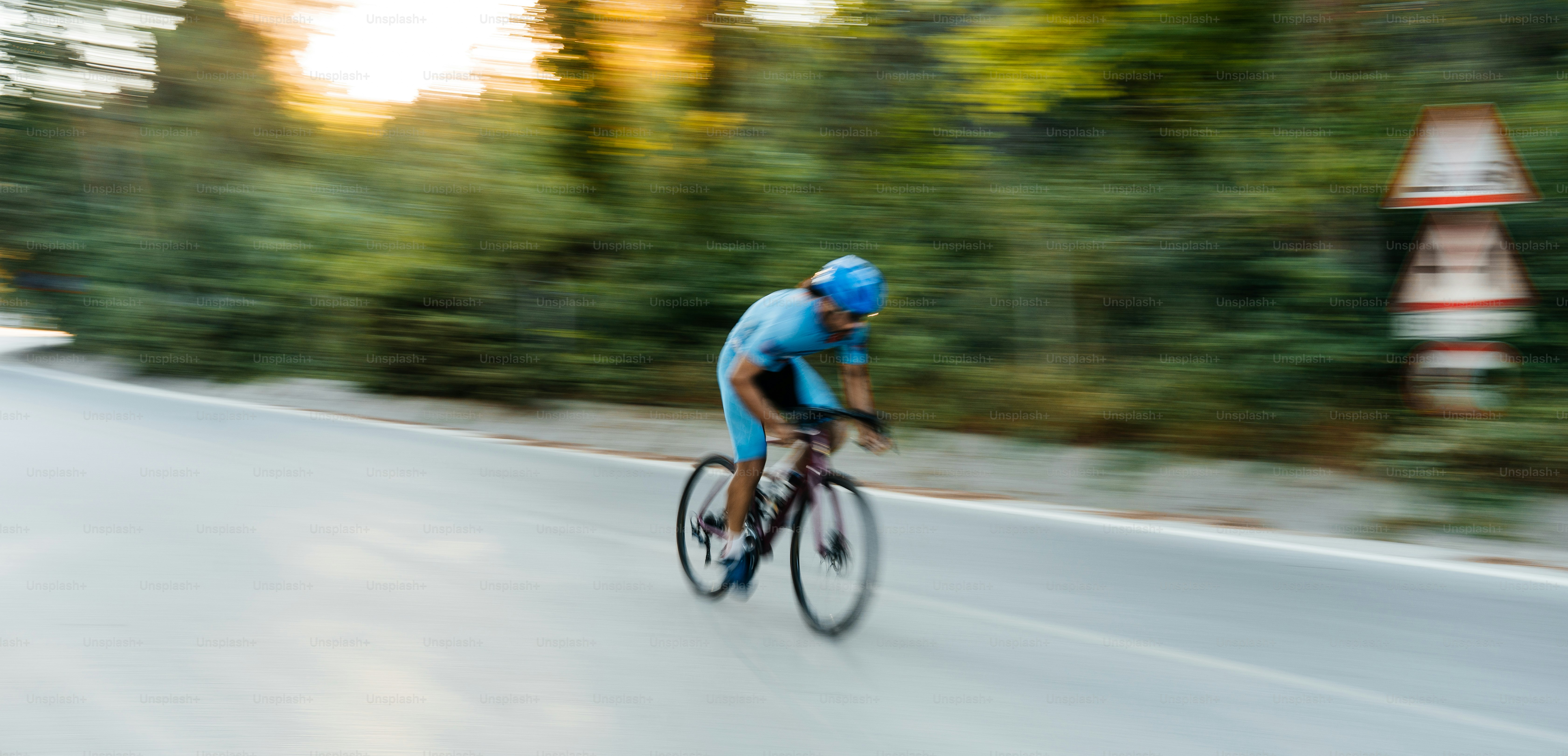 A cyclist races down a road at high speed. photo – Sport Image on Unsplash