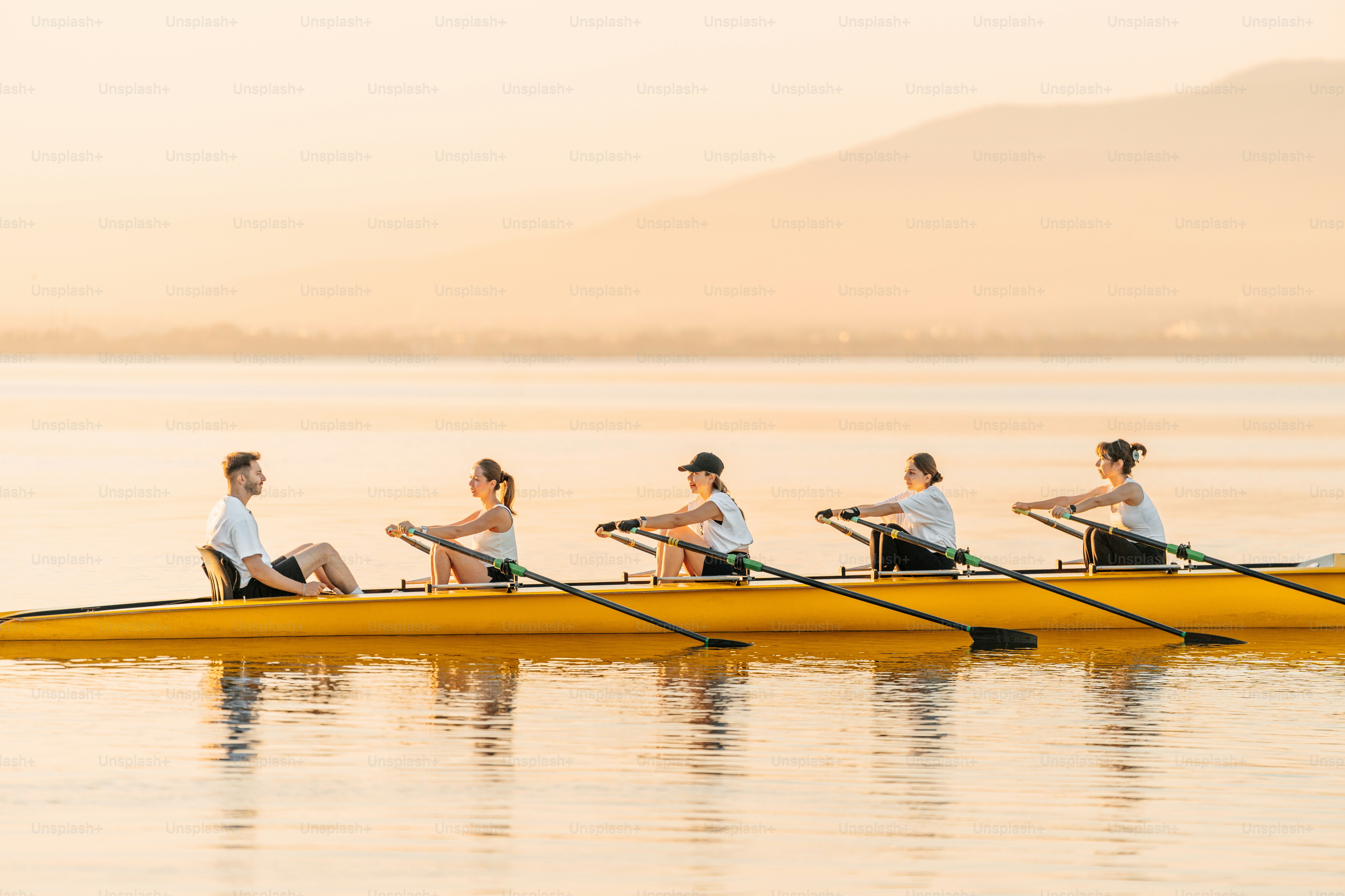 A rowing team competes on calm, blue waters. photo – Sunset Image on ...
