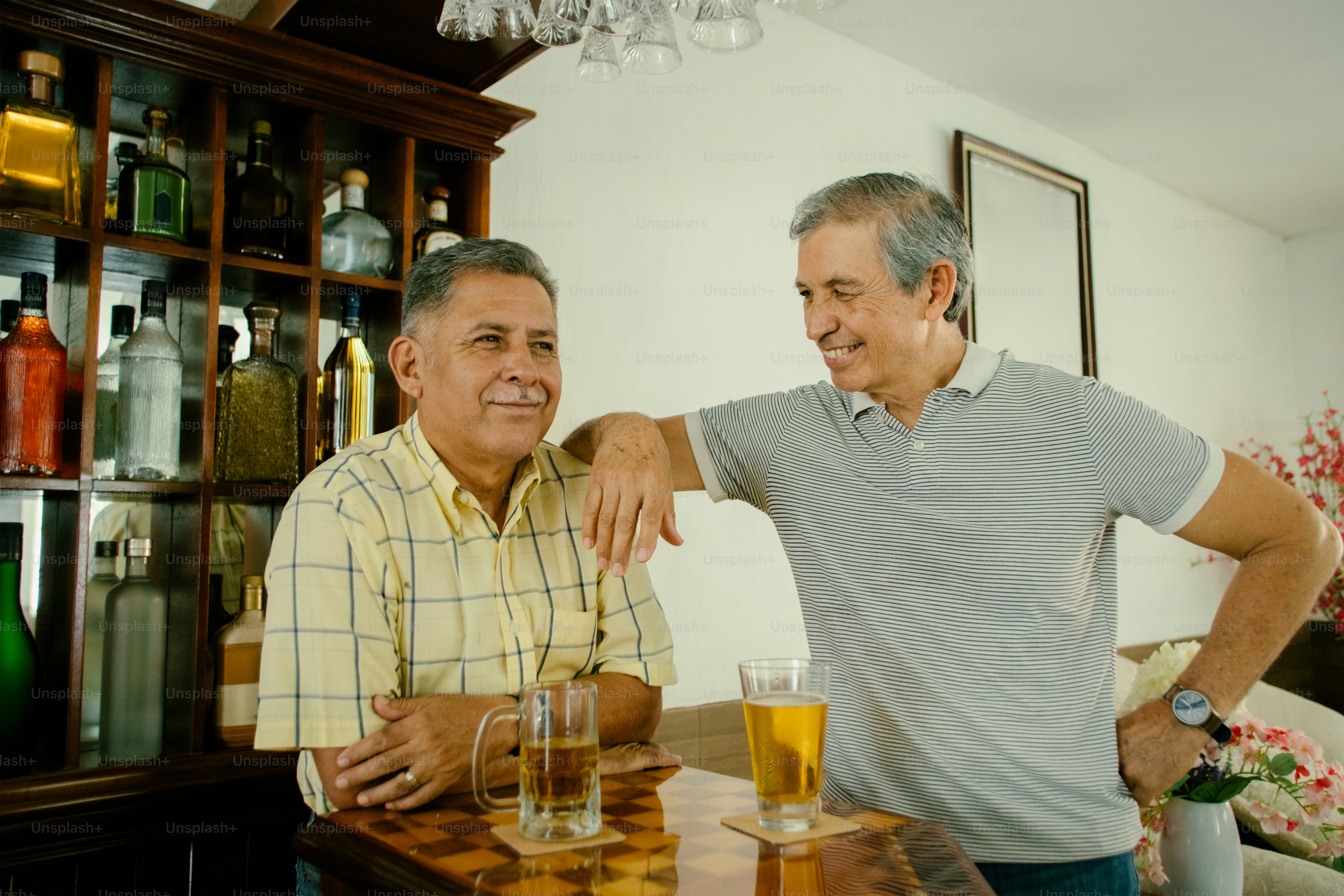 Two men share drinks and a friendly chat. photo – Friends Image on Unsplash