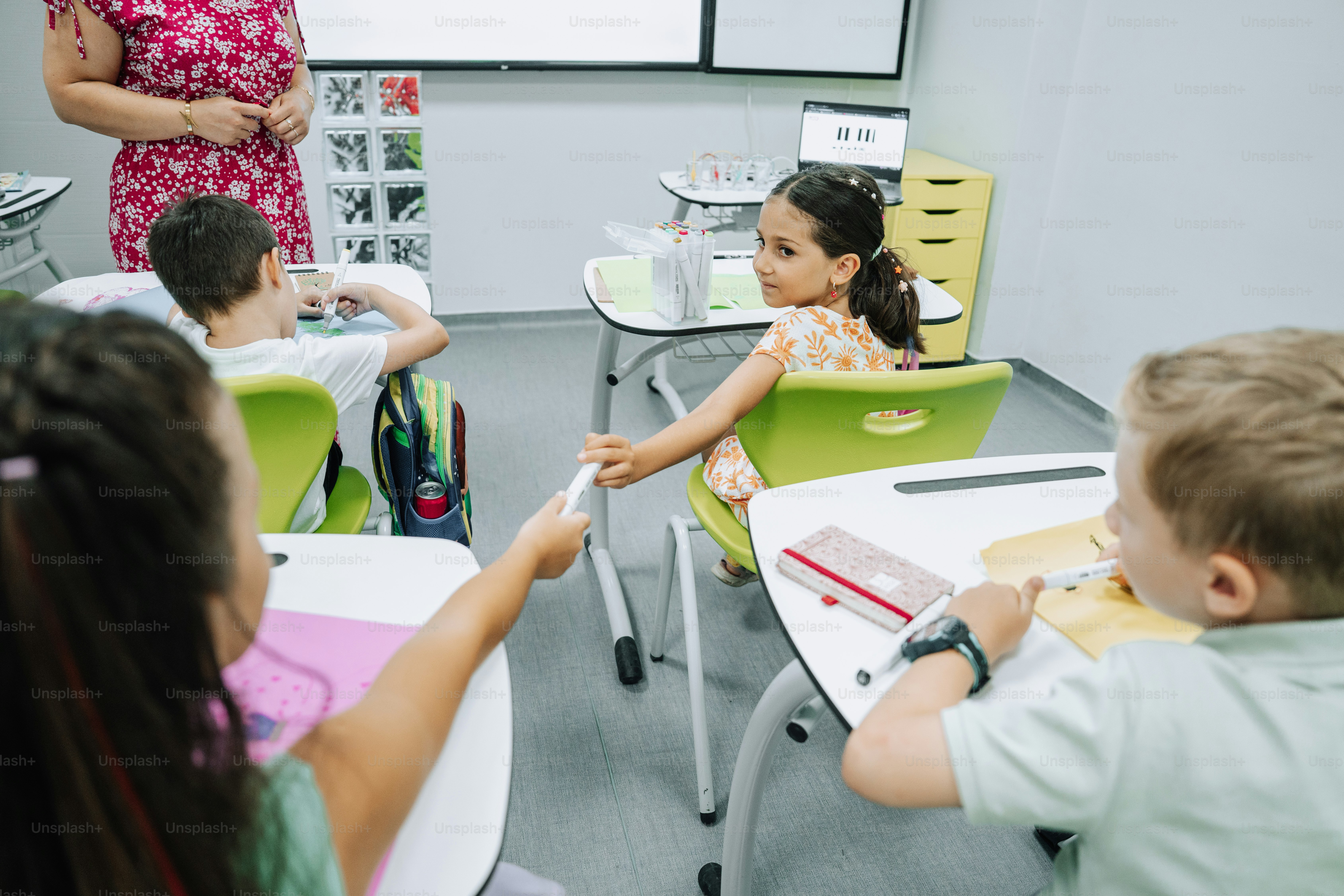 Children share items during class time in the classroom. photo ...