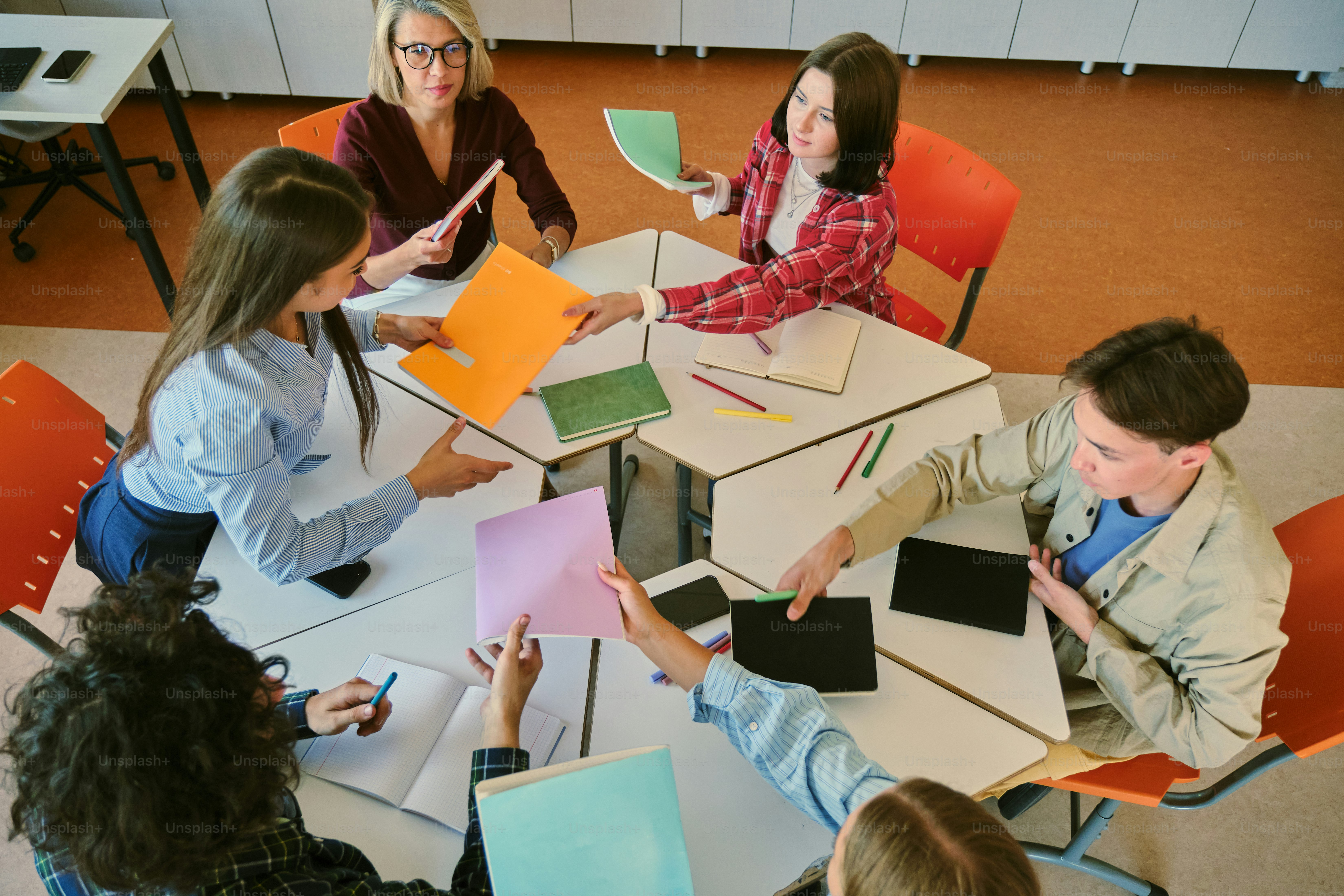 Students are collaborating around a table. photo – School Image on Unsplash