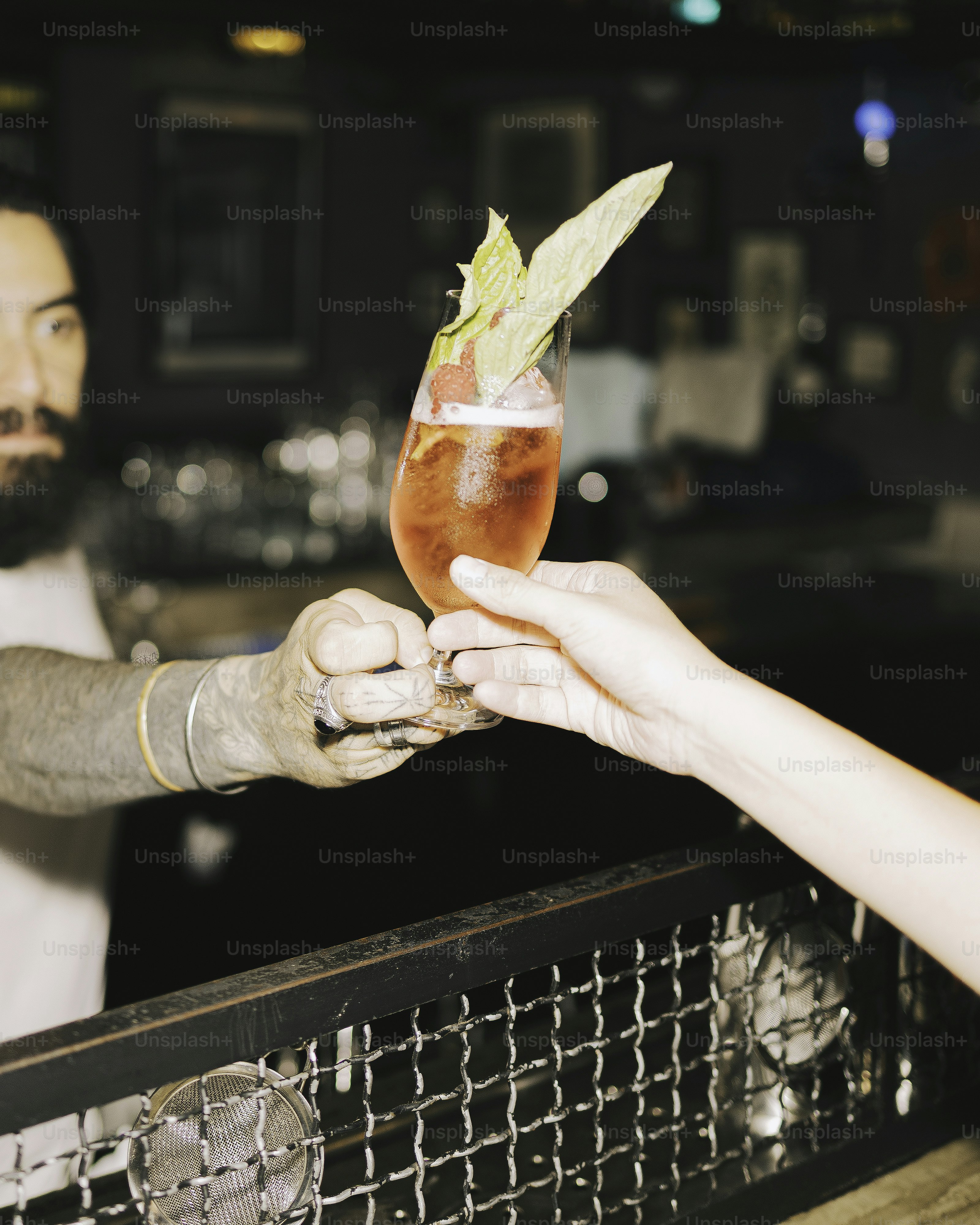 A bartender handing a cocktail to a customer. photo – Bar Image on Unsplash