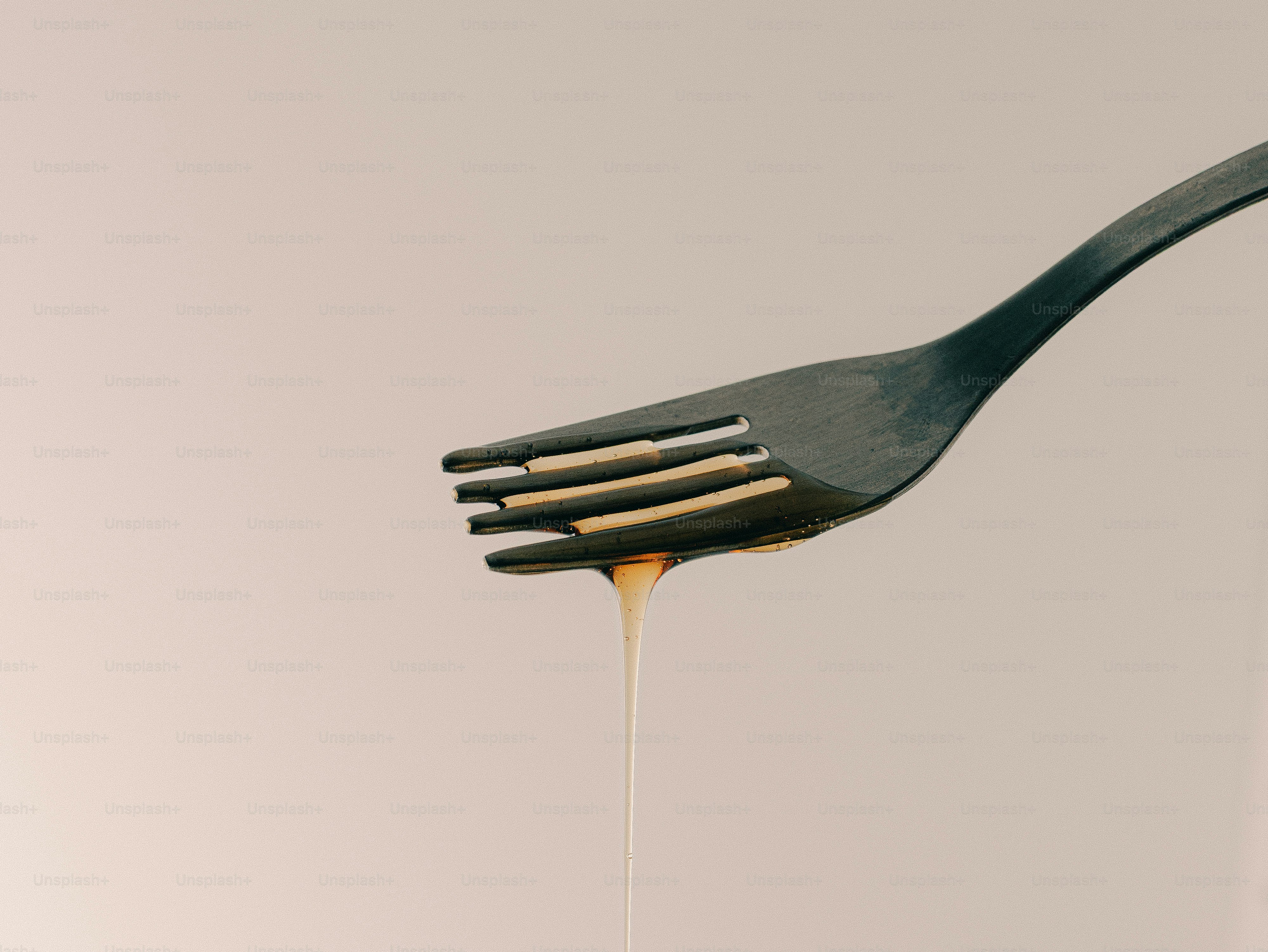 A fork holds dropping sauce. photo – Minimalist Image on Unsplash