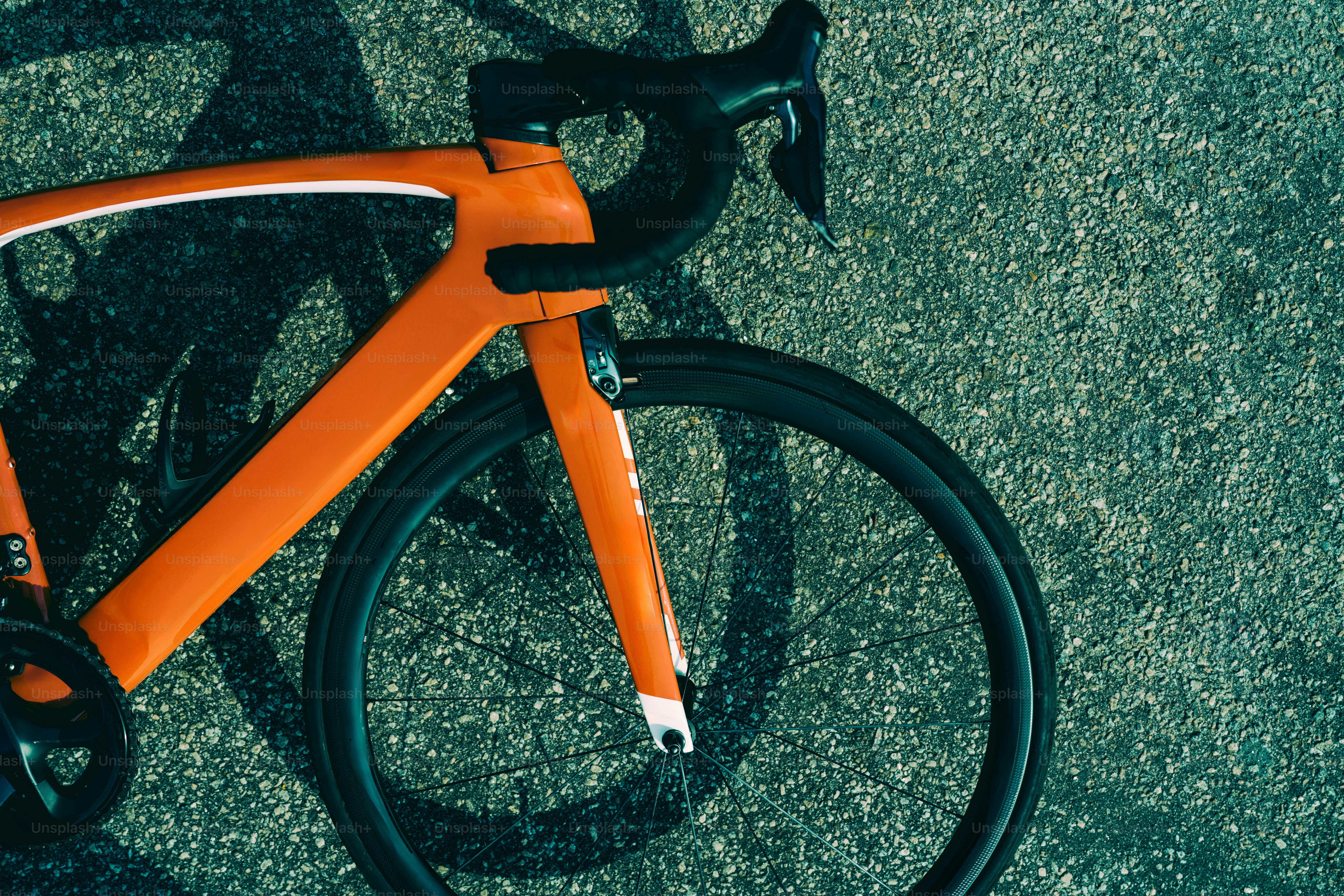 An orange road bike is posed on the ground. photo – Sport Image on Unsplash